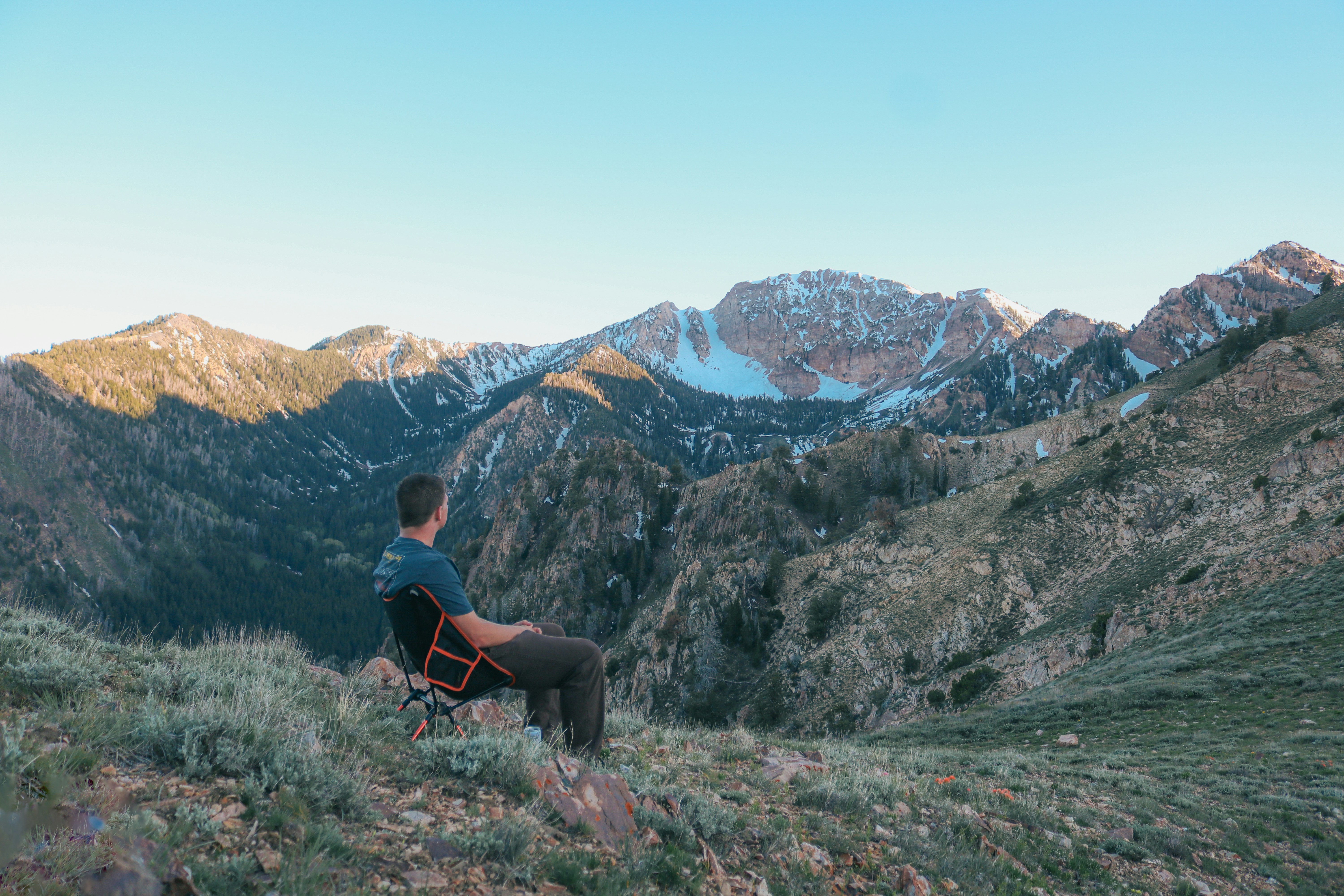 A person enjoys mountain views from a chair.