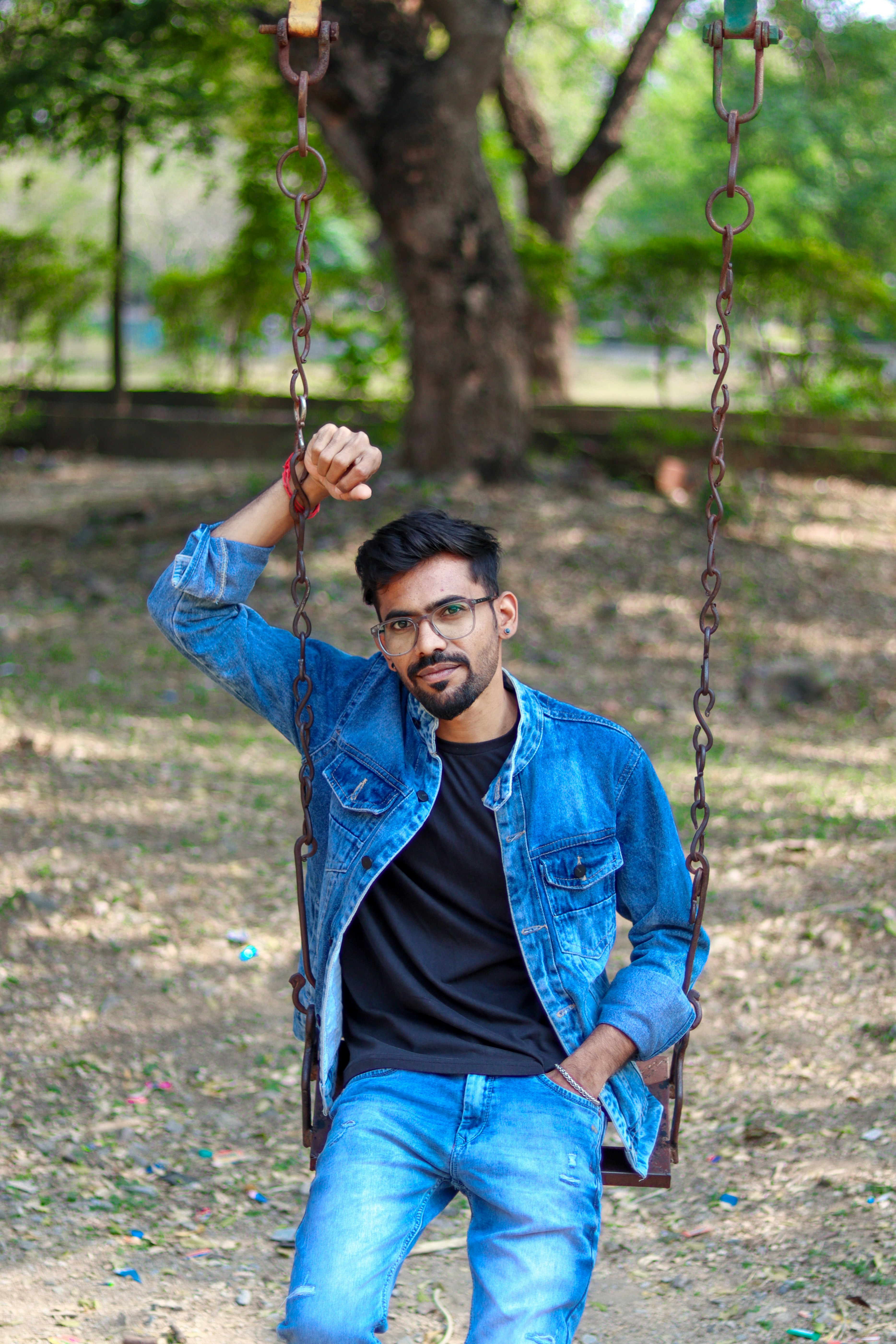A man poses on a swing set in the park. photo – Free Forest Image on ...