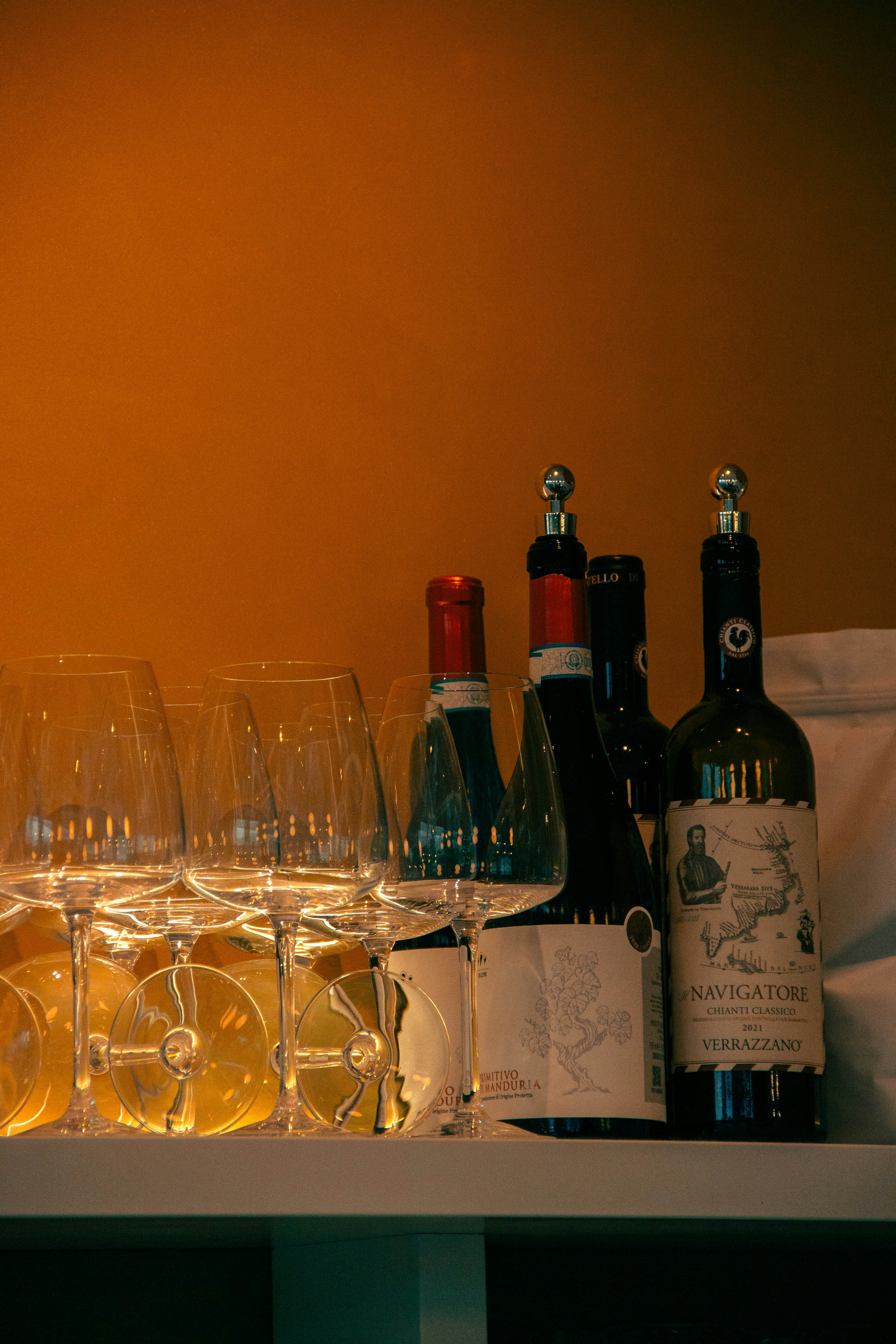 Wine bottles and glasses are neatly arranged.