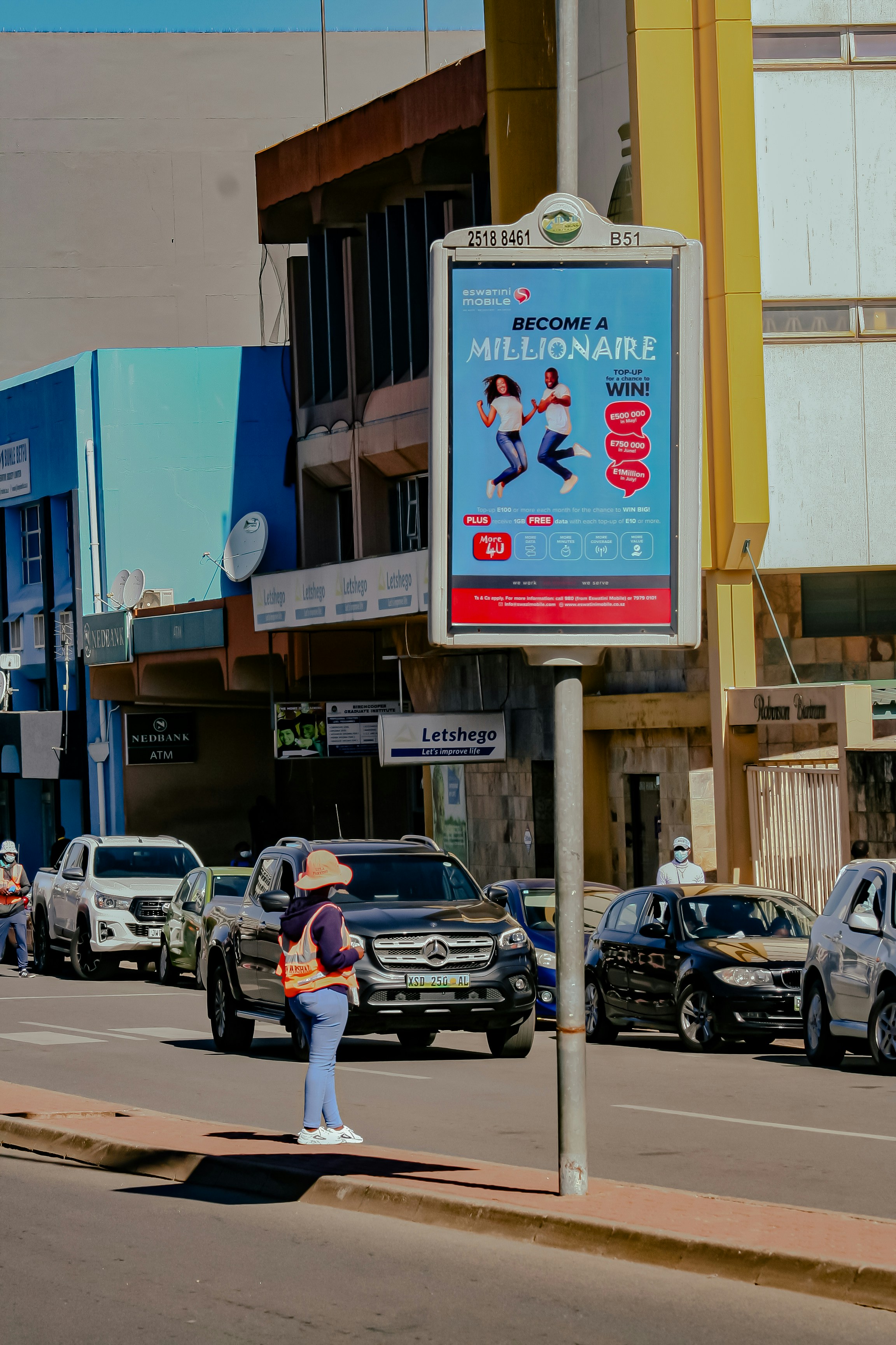 Street Scene Spotlight: A Volunteer in the Crosswalk of Colorful Urban Facades