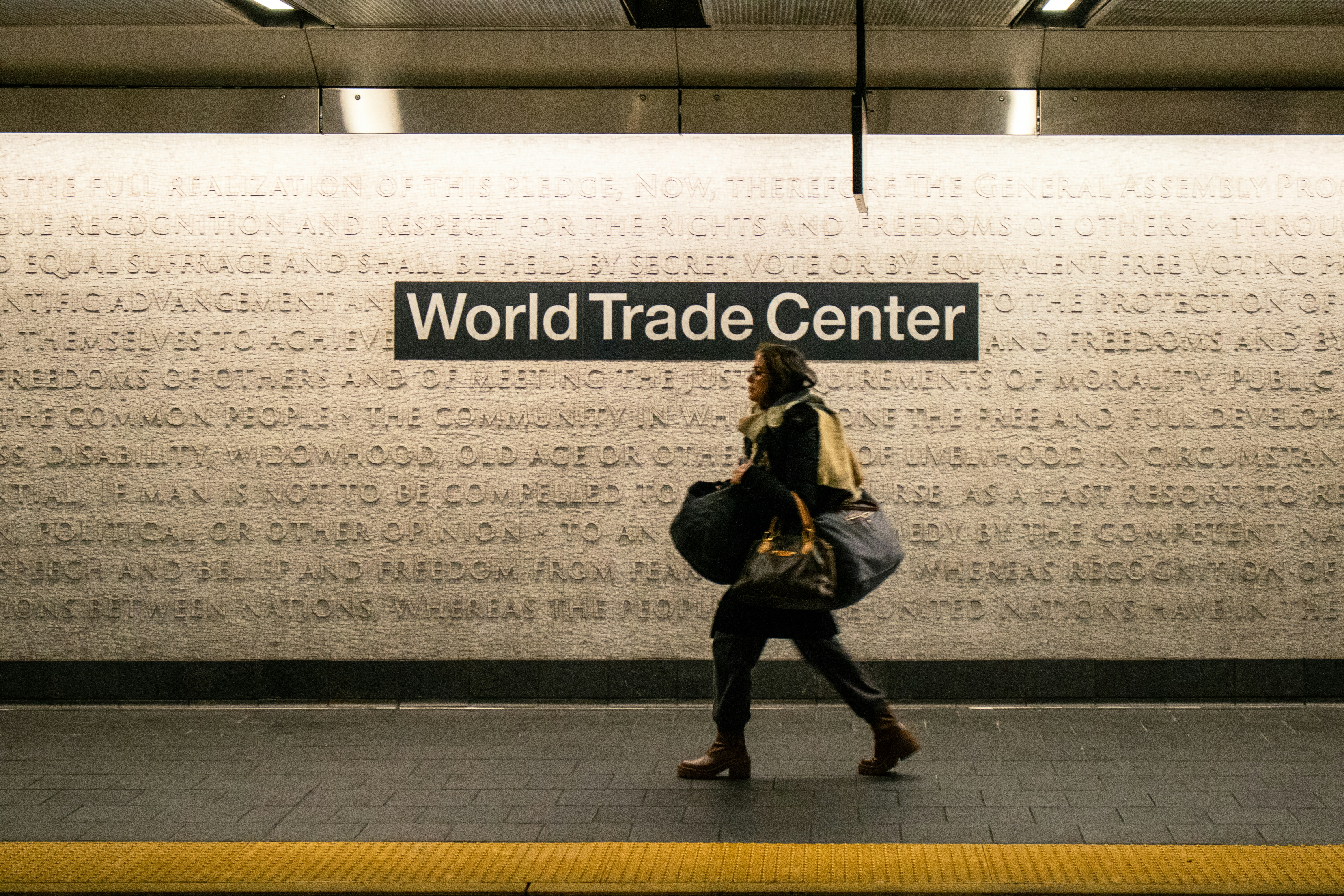 Footsteps Against a Wall of Names at the World Trade Center Station