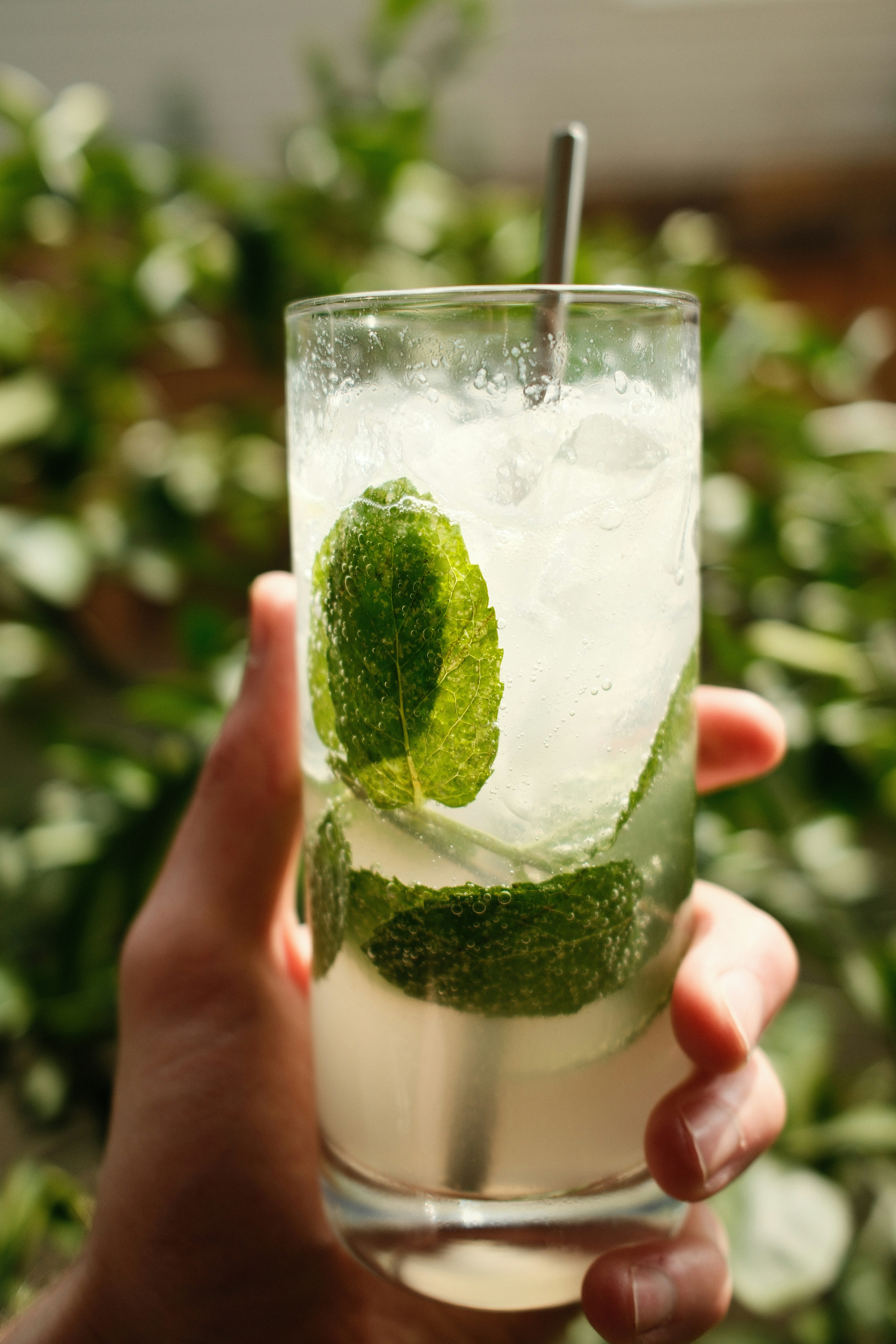 Hand holding a refreshing mojito cocktail.