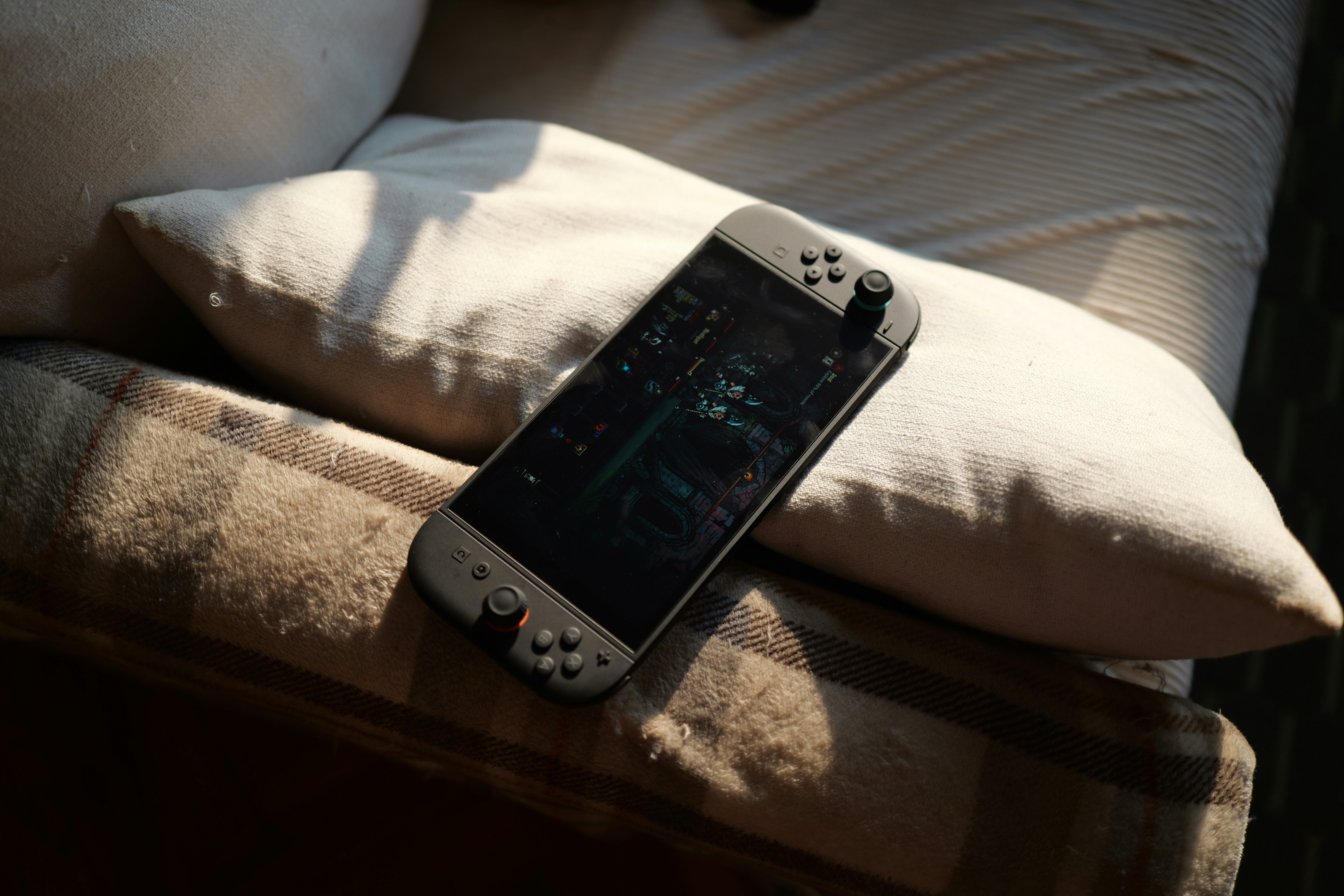 A handheld gaming console rests on pillows. photo – Free Nintendo switch 2 Image on Unsplash