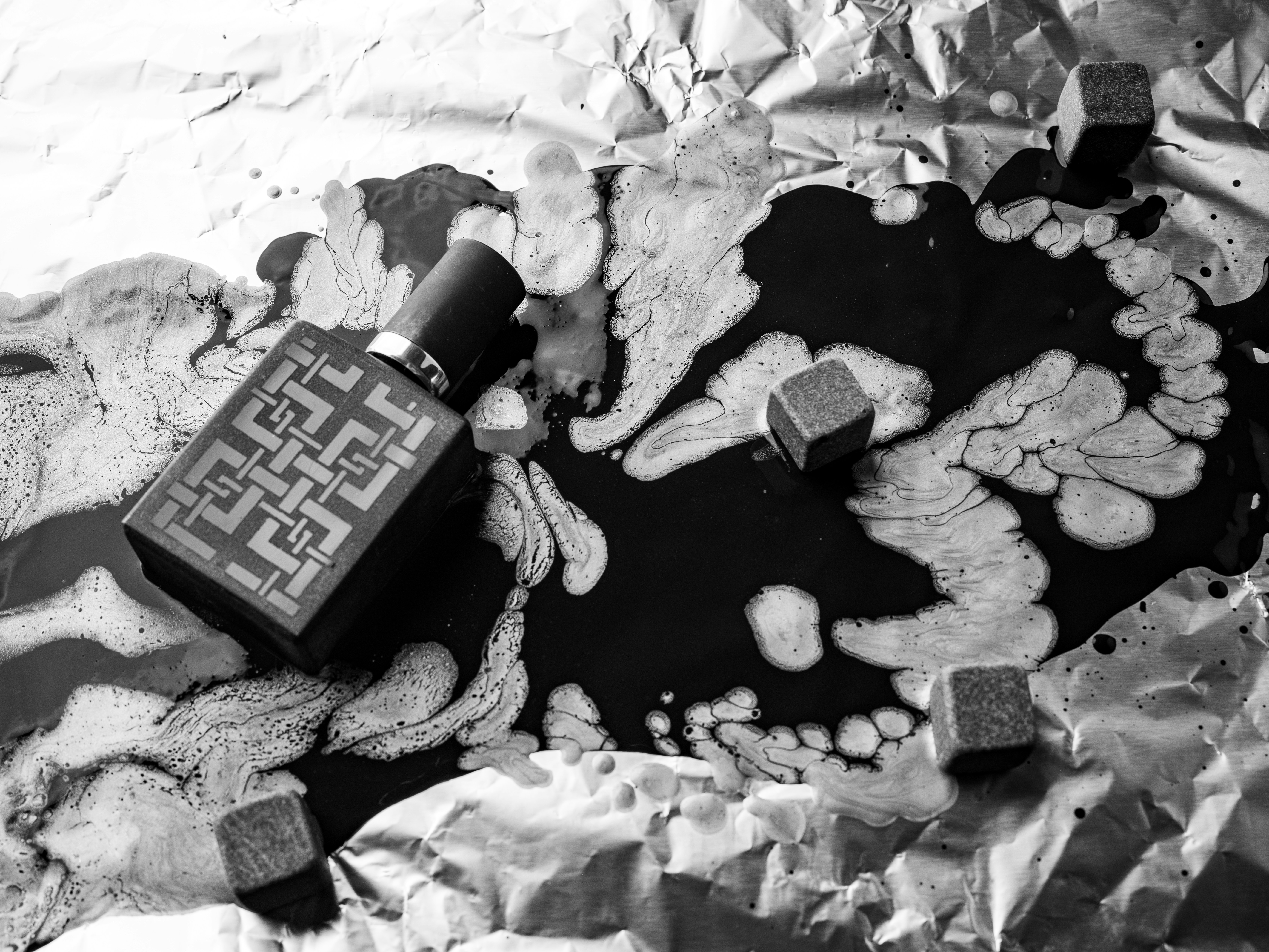 Perfume bottle and cubes on aluminum foil with spill. photo – Free ...
