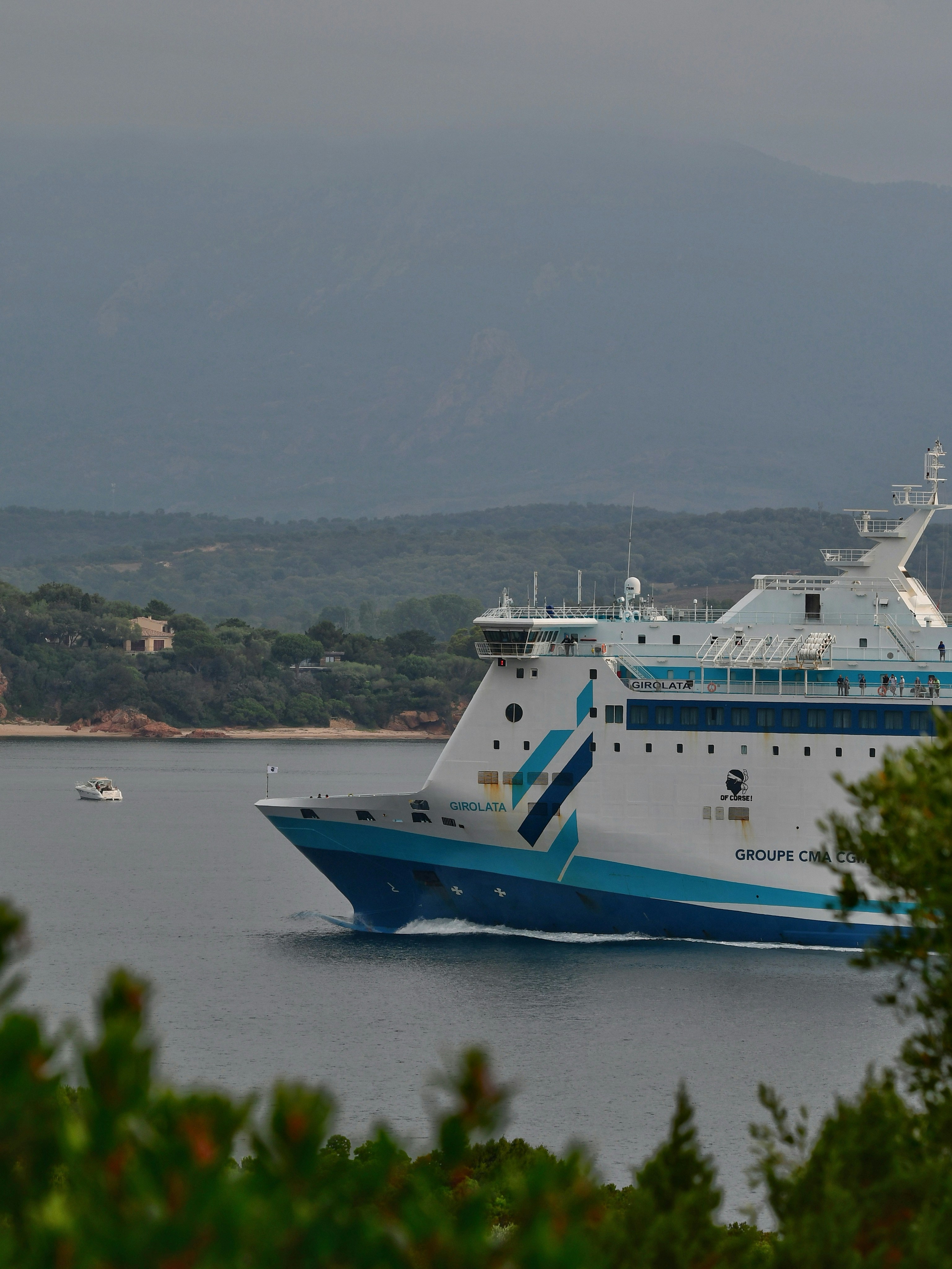 Bow in the Quiet Harbor: A Blue-and-White Cruise Ship Before Misty Mountains