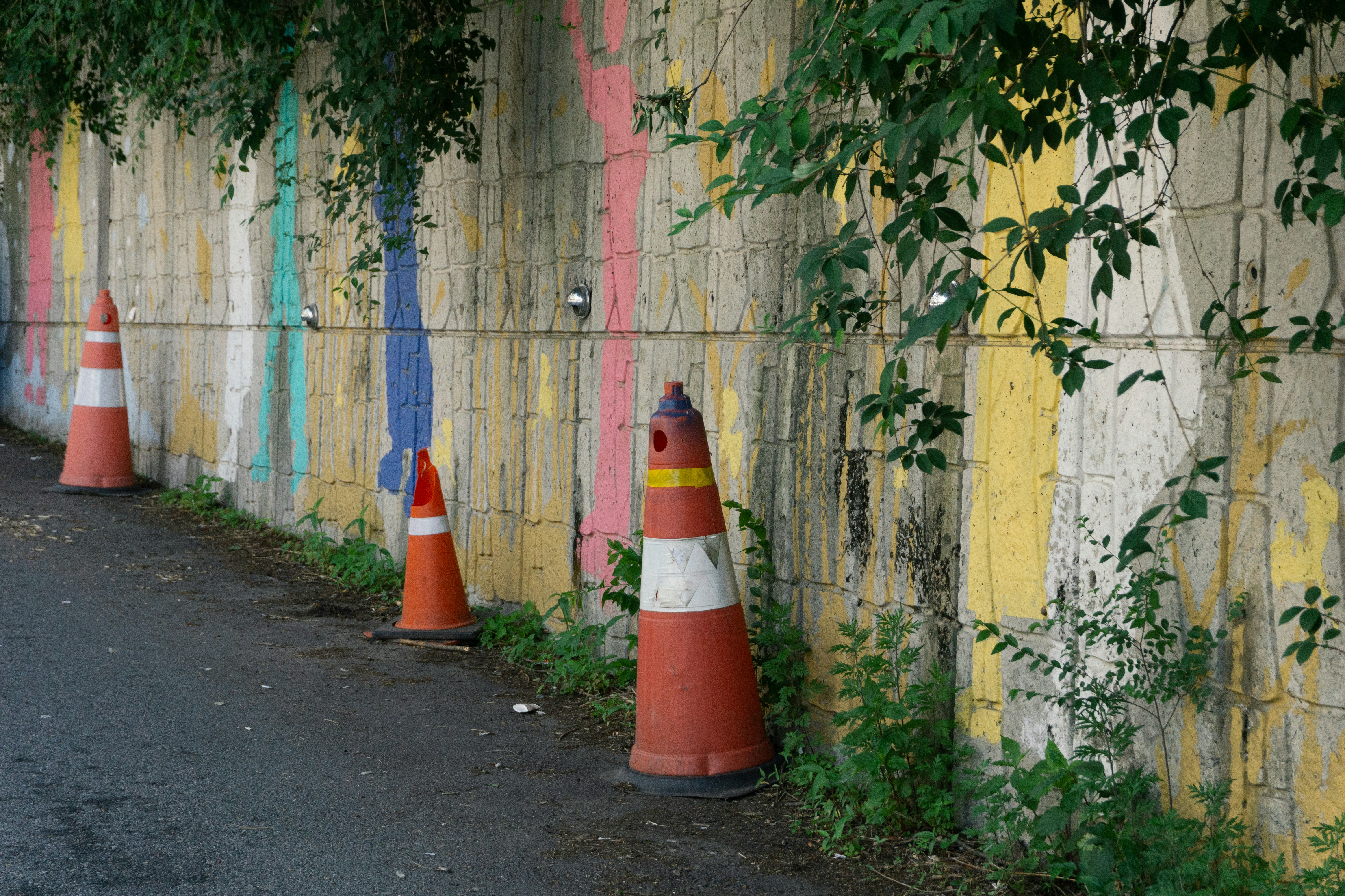 Traffic cones line a colorful, weathered wall. photo – Free City Image ...