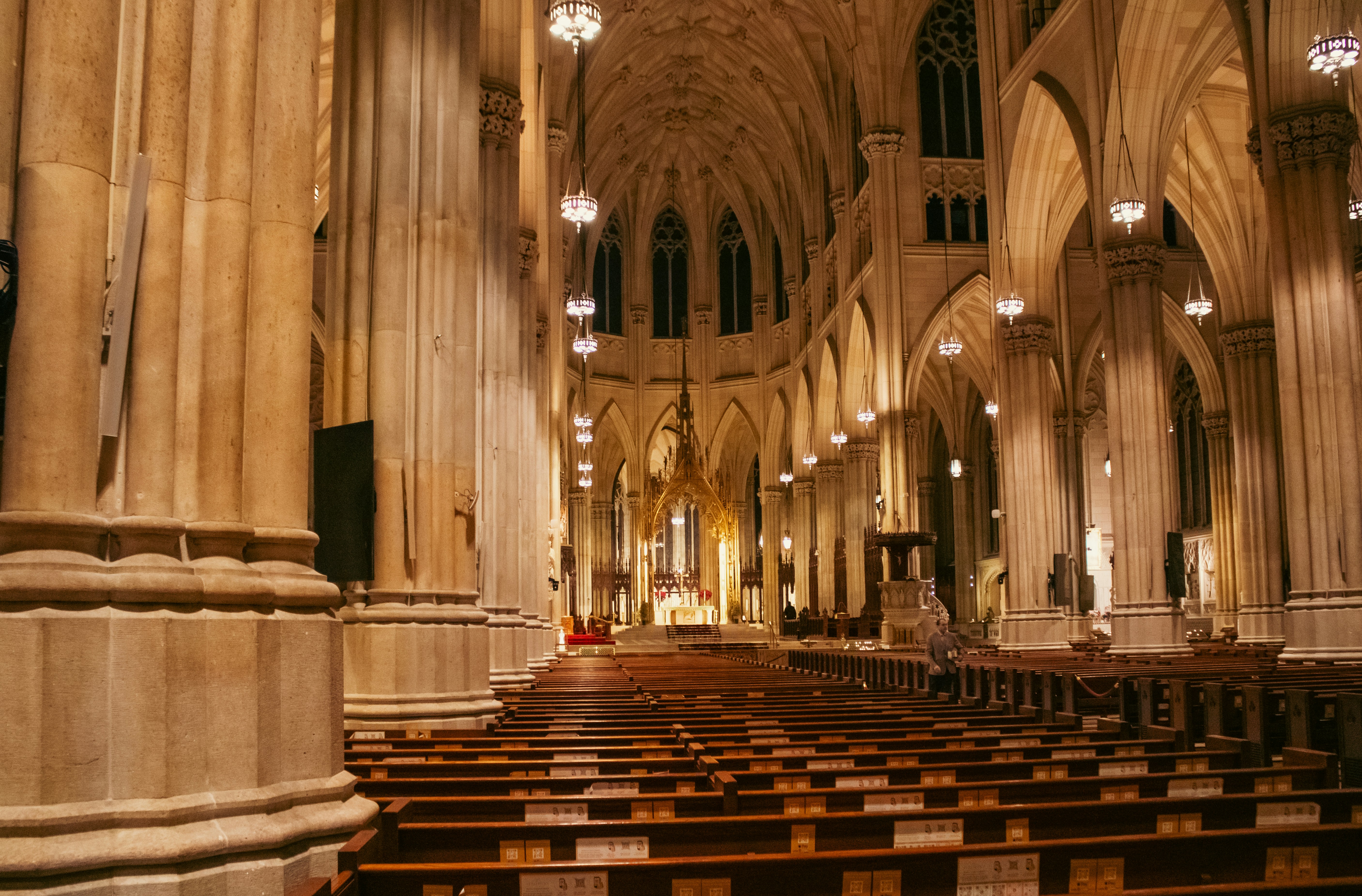 The interior of St. Patrick’s Cathedral in Manhattan, New York City, showcases stunning neo-gothic architecture with soaring arches, intricate stained glass, and a serene, sacred atmosphere. This historic landmark remains one of NYC’s most iconic and awe-inspiring spiritual spaces. | The interior of a grand cathedral is shown.