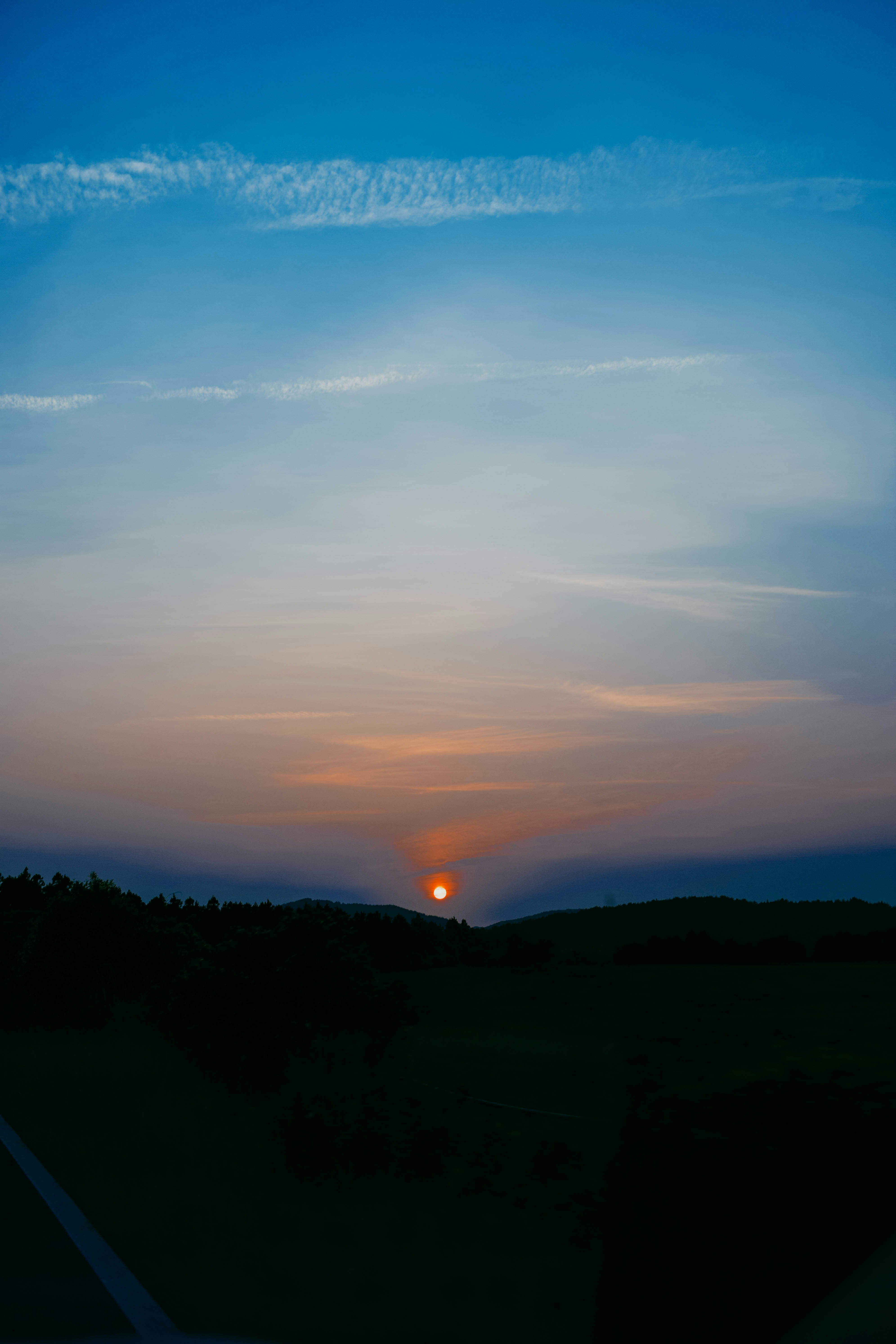 Sunset over a dark landscape and light blue sky. photo – Free Sunset ...