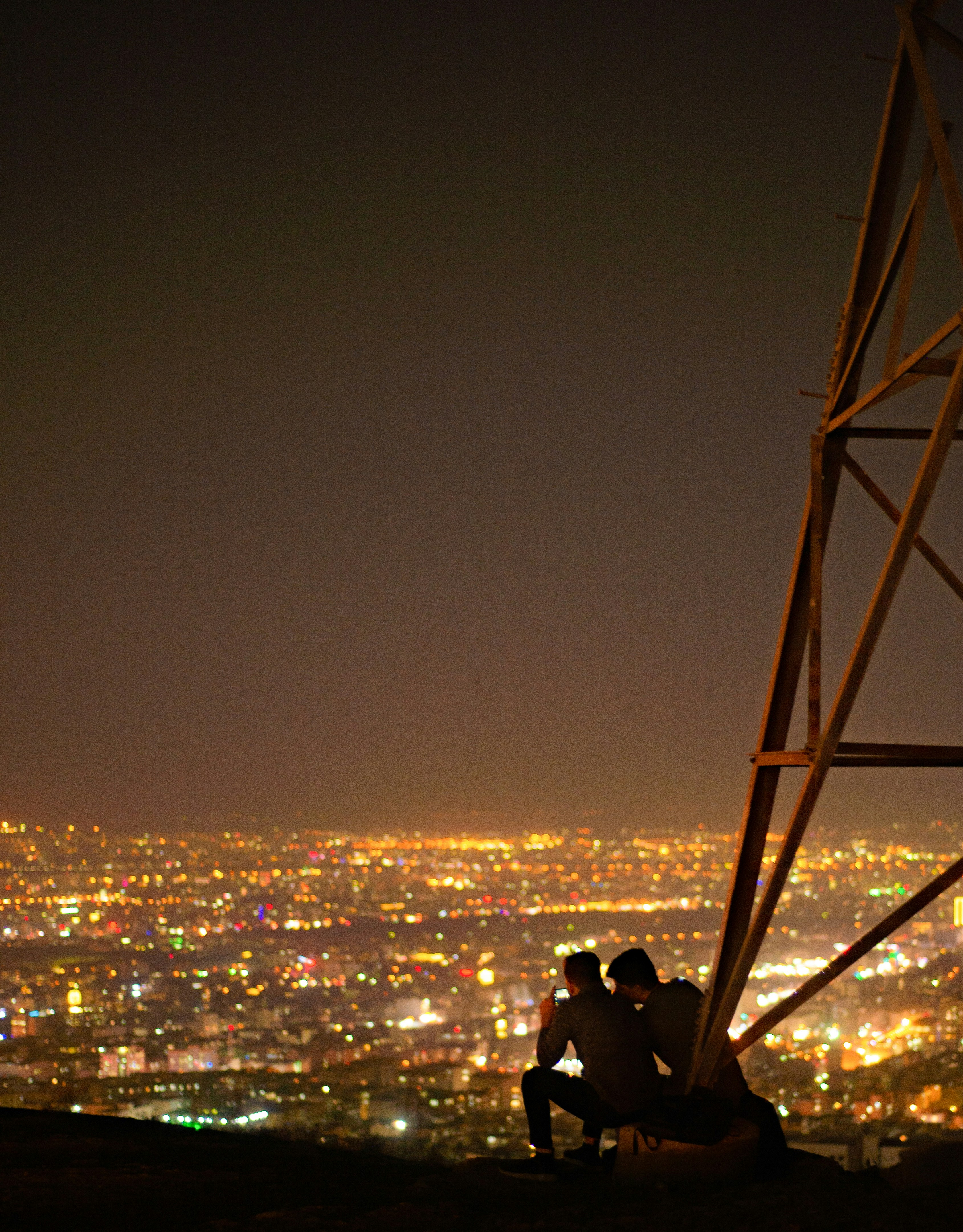 Vigil on the Hill: Two Silhouettes Against a City of Lights