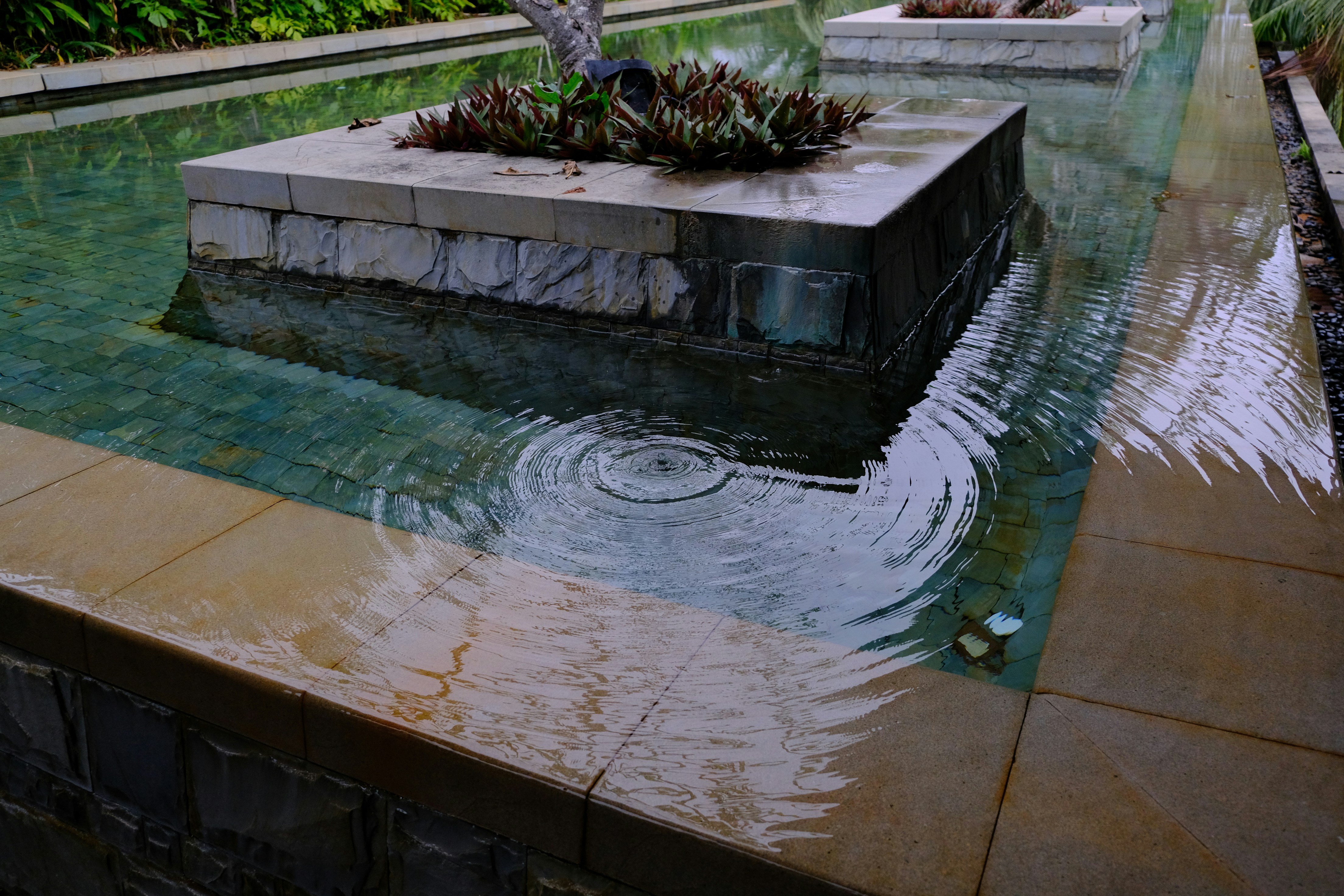 Water ripples in a tranquil, rectangular pool.