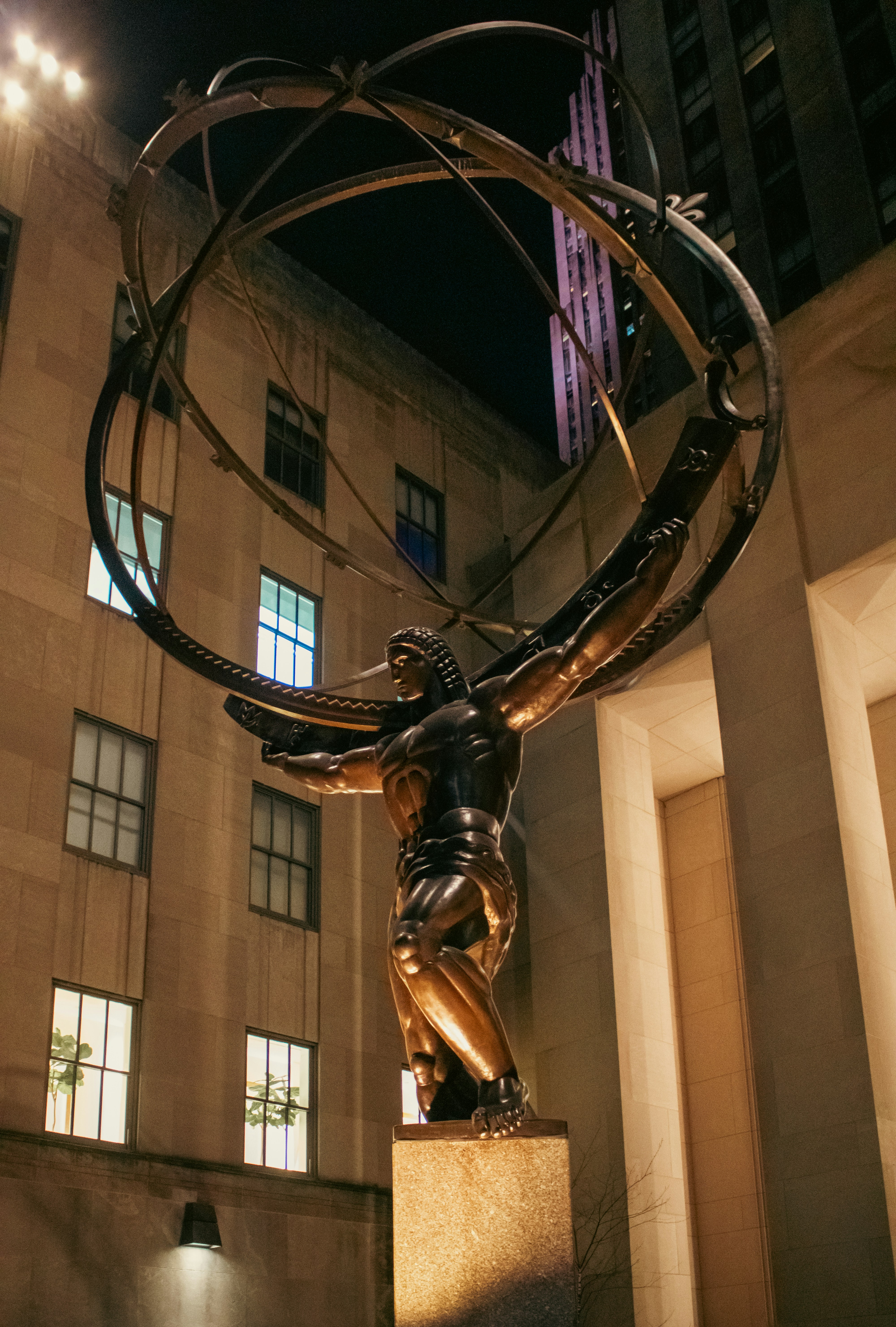 Arms in Orbit: The Atlas Statue Under Night Neon
