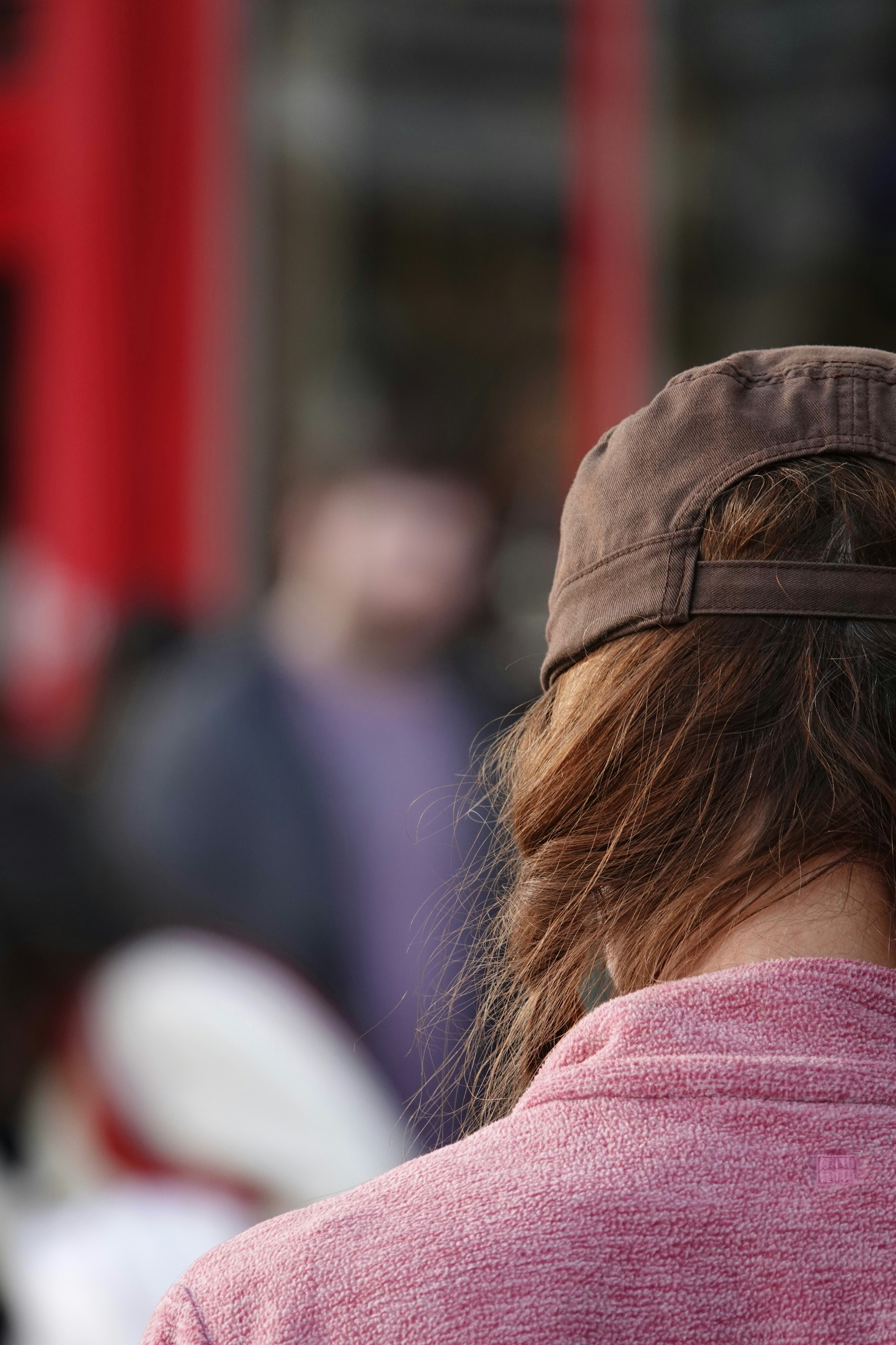 Behind the Crowd: A Pink-Toned Portrait in a City Blur