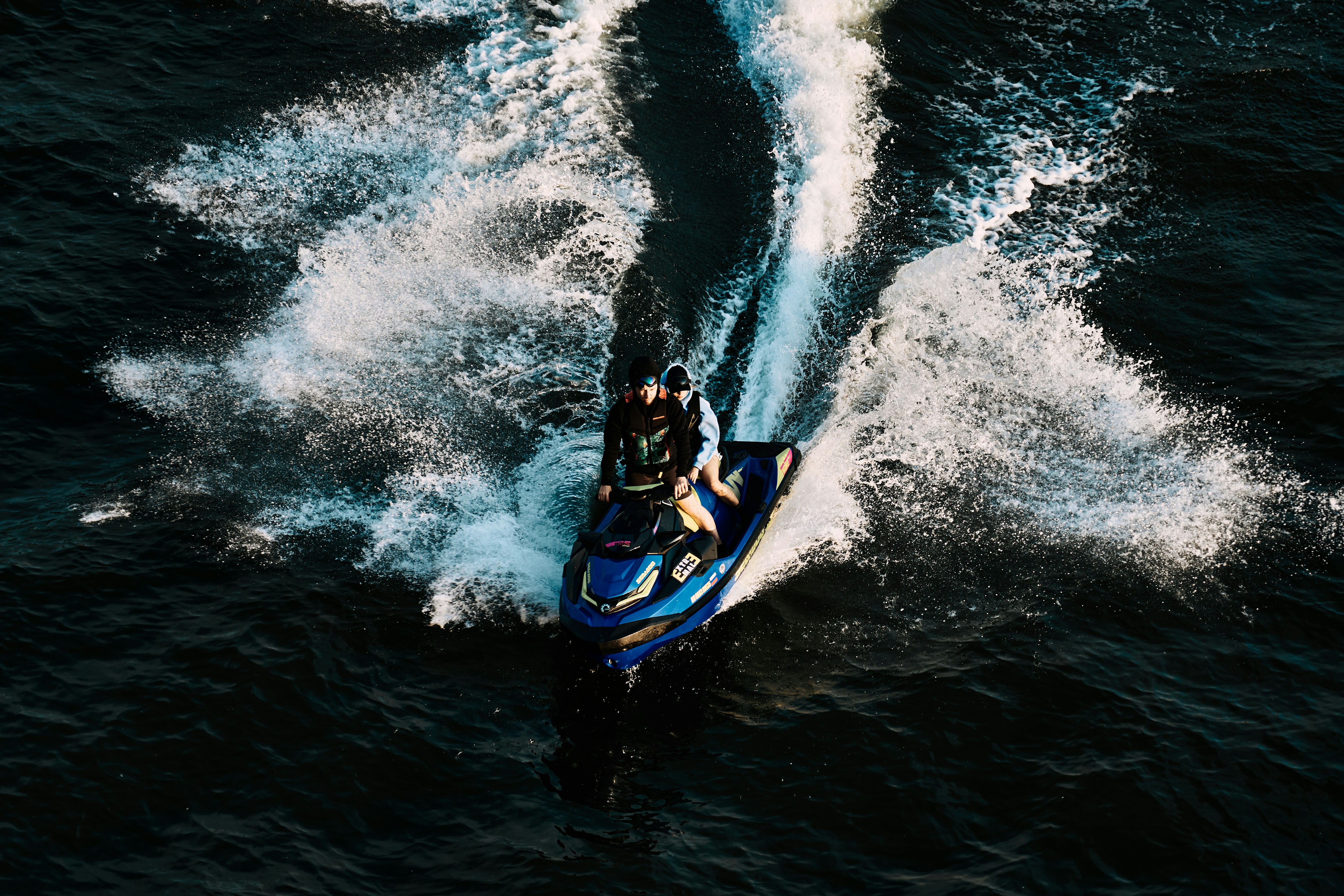 A jet ski speeds across the dark ocean waters. photo – Free Human Image ...