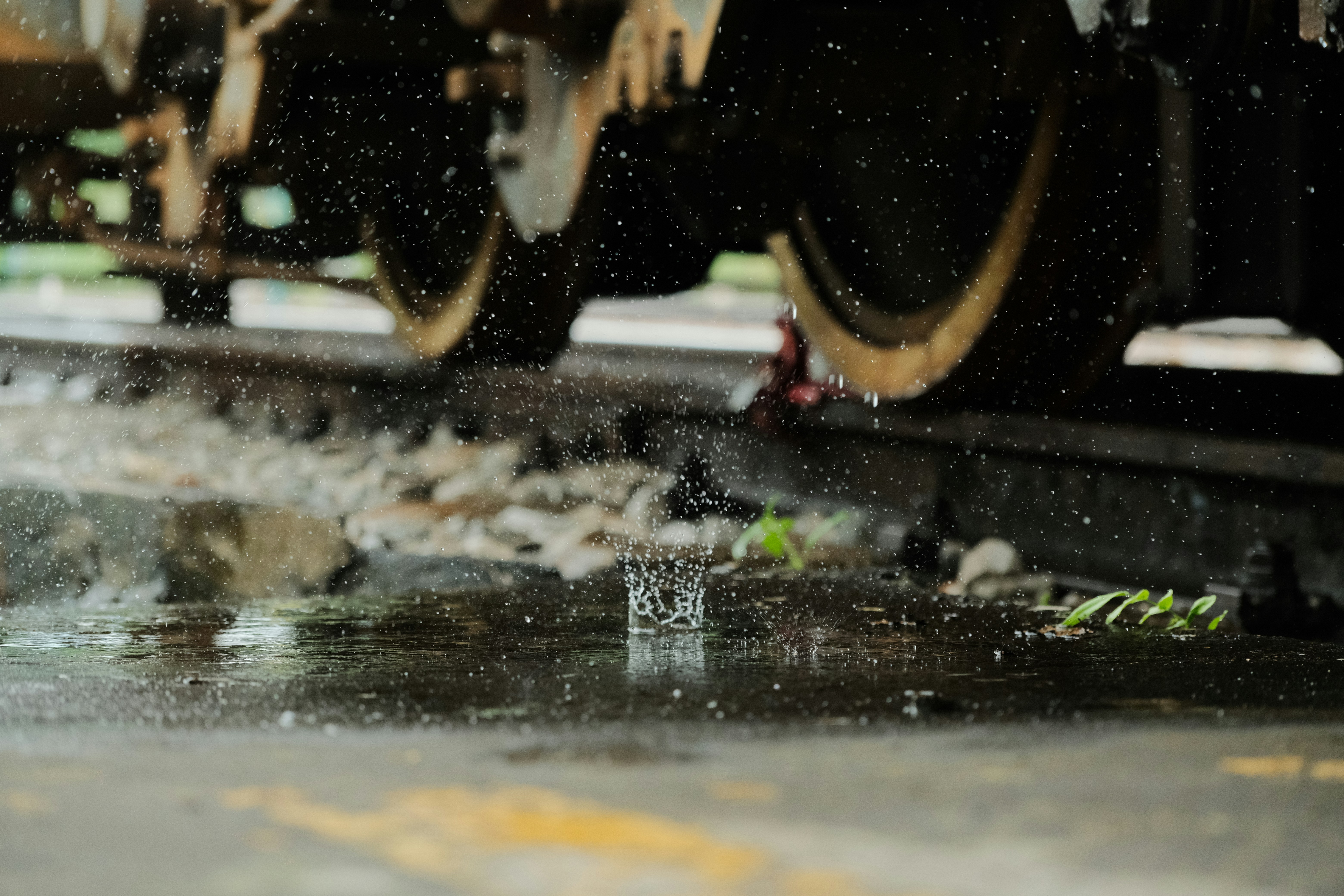 Hydro Burst Beneath Blurred Wheels: A Rain-Slick Moment