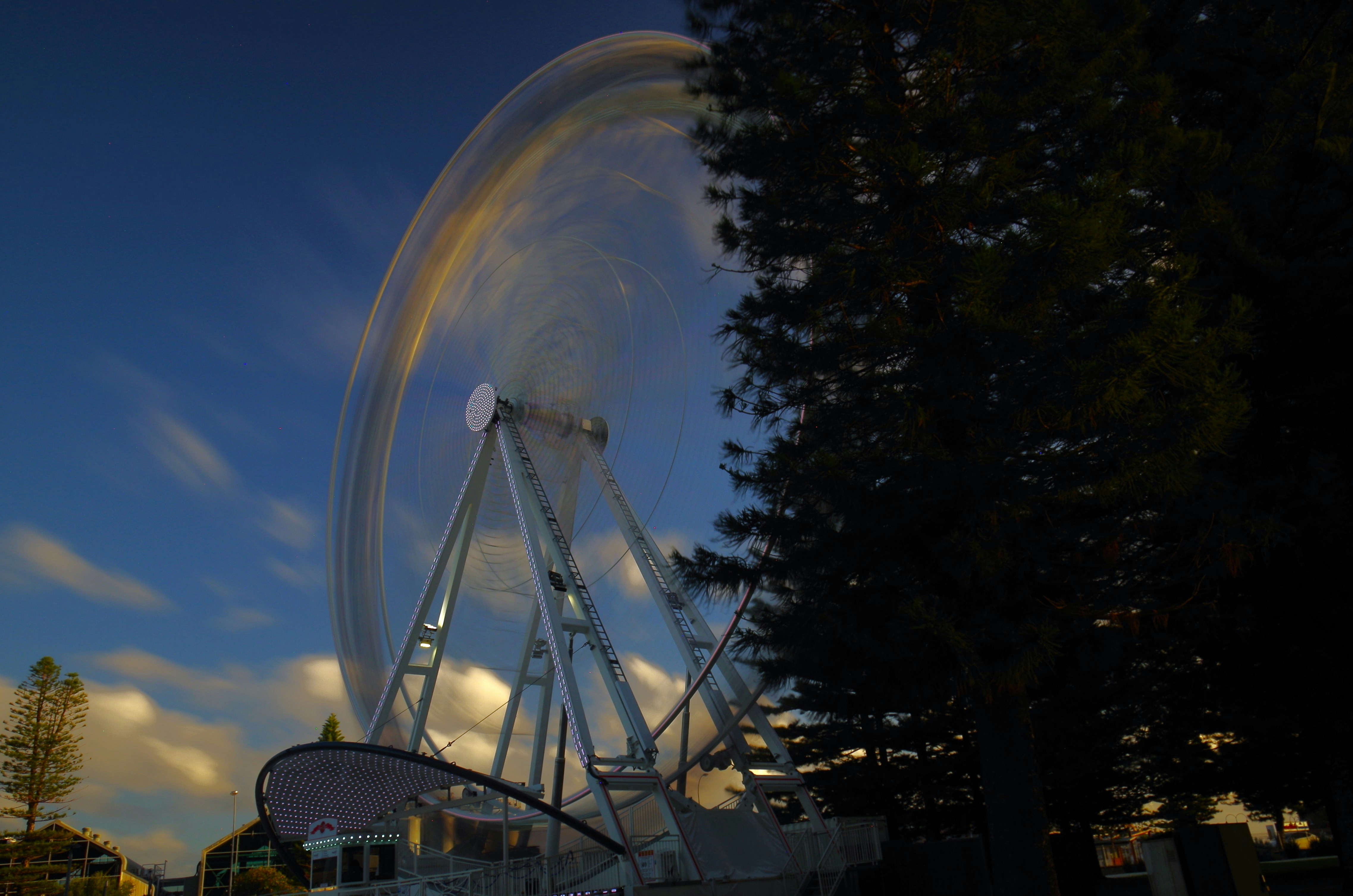 Spin of Steel and Sky: Nighttime Ferris Wheel in Motion