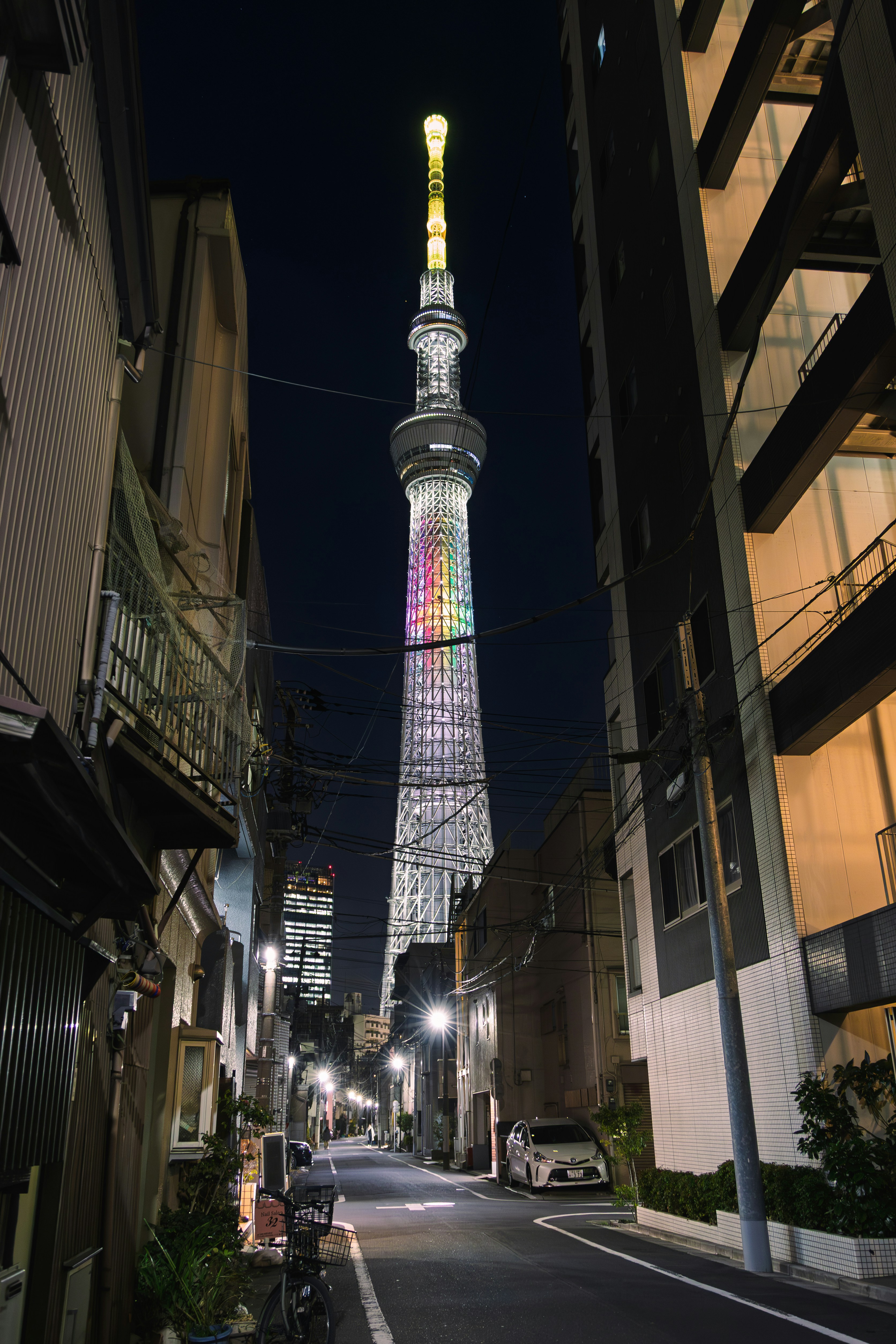 Tokyo skytree towers over a narrow street at night. photo – Free Car Image on Unsplash