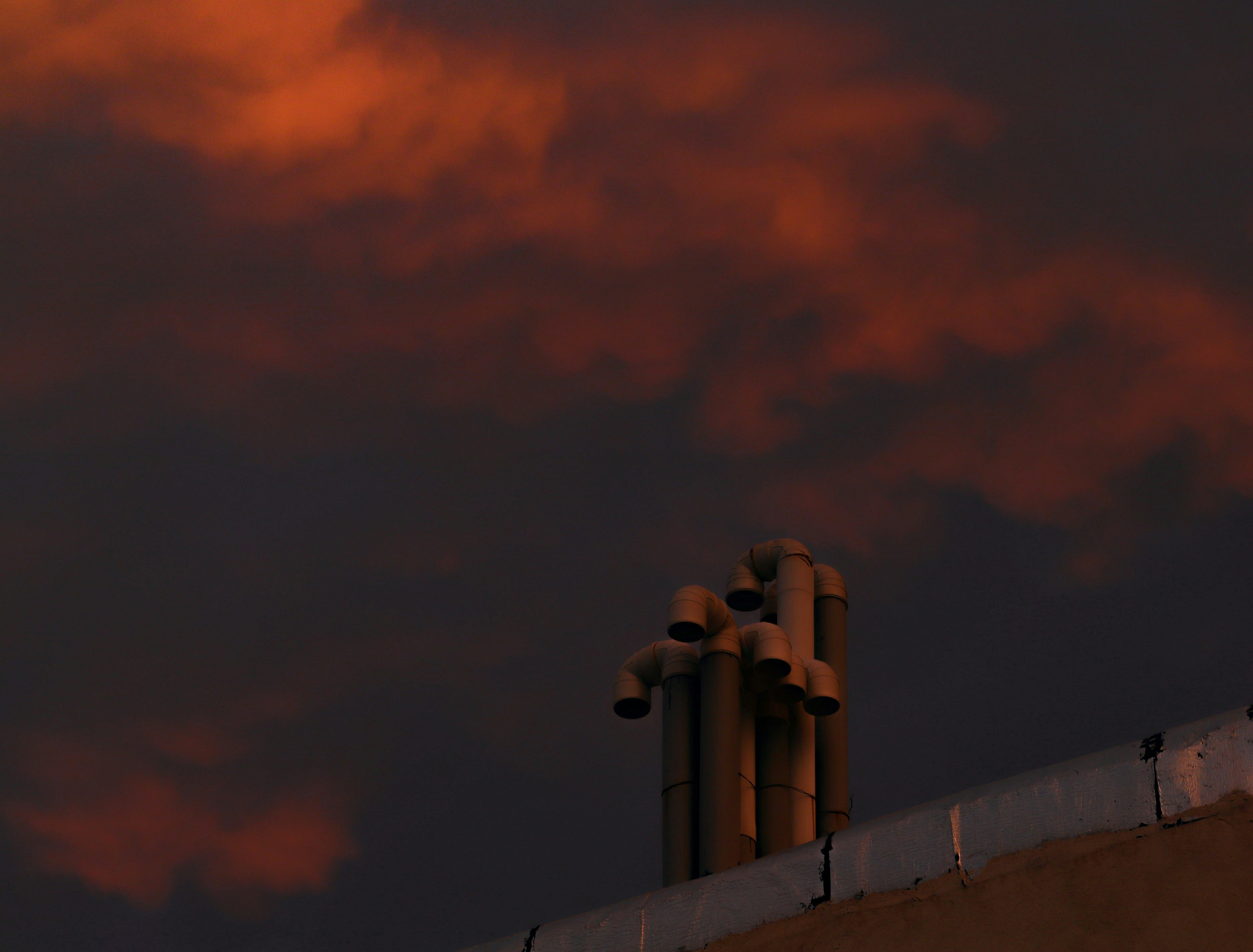 Rooftop Chorus: Copper Pipes Against a Dusk-Embered Sky