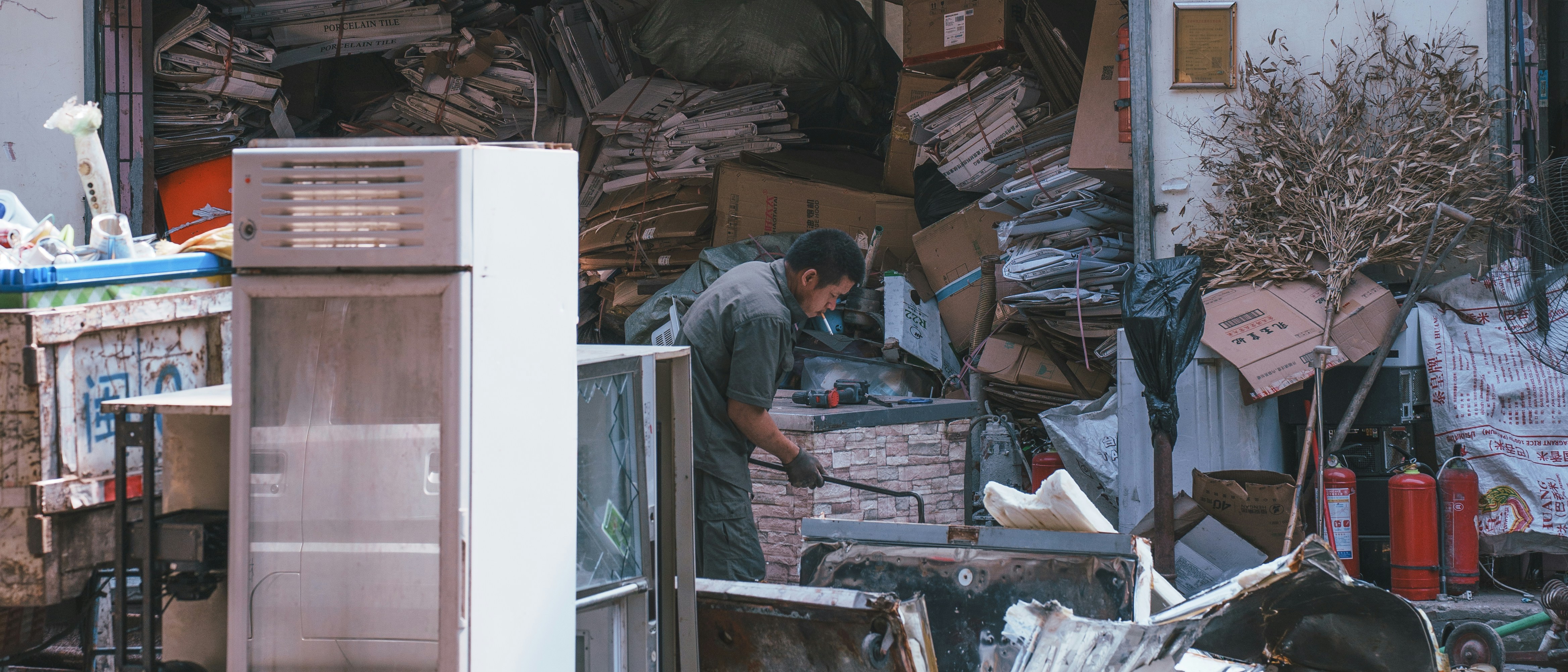 A man works among clutter and debris.