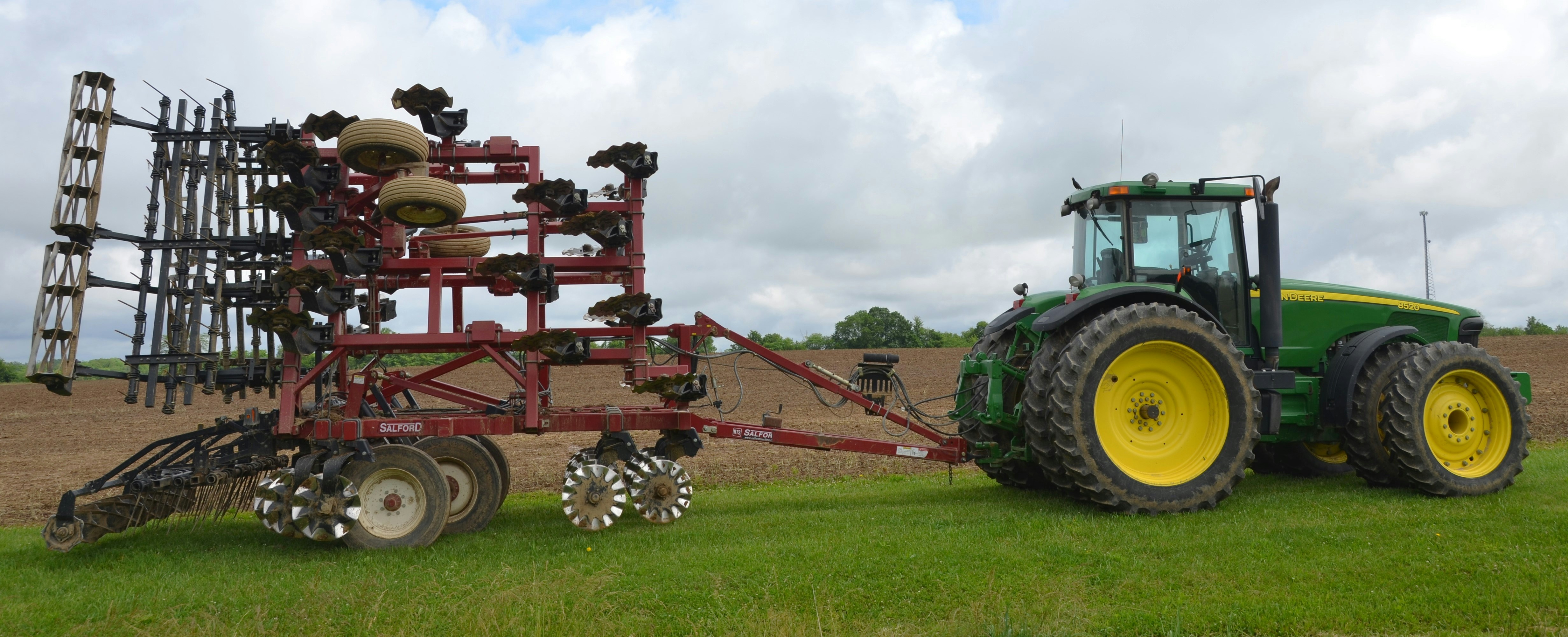 A tractor pulls a large farming implement. photo – Free Farm Image on ...