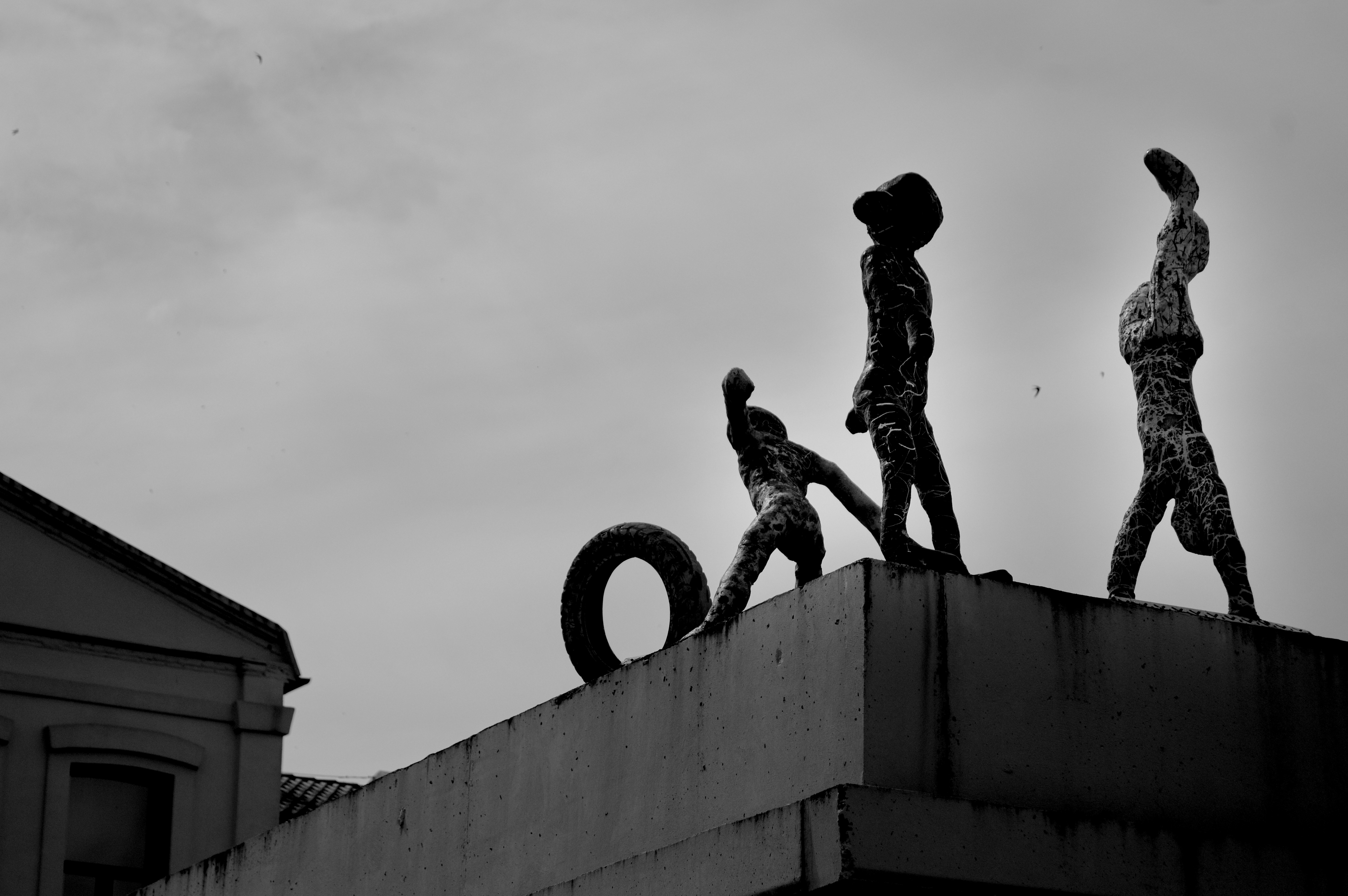 Figures stand silhouetted against the cloudy sky.
