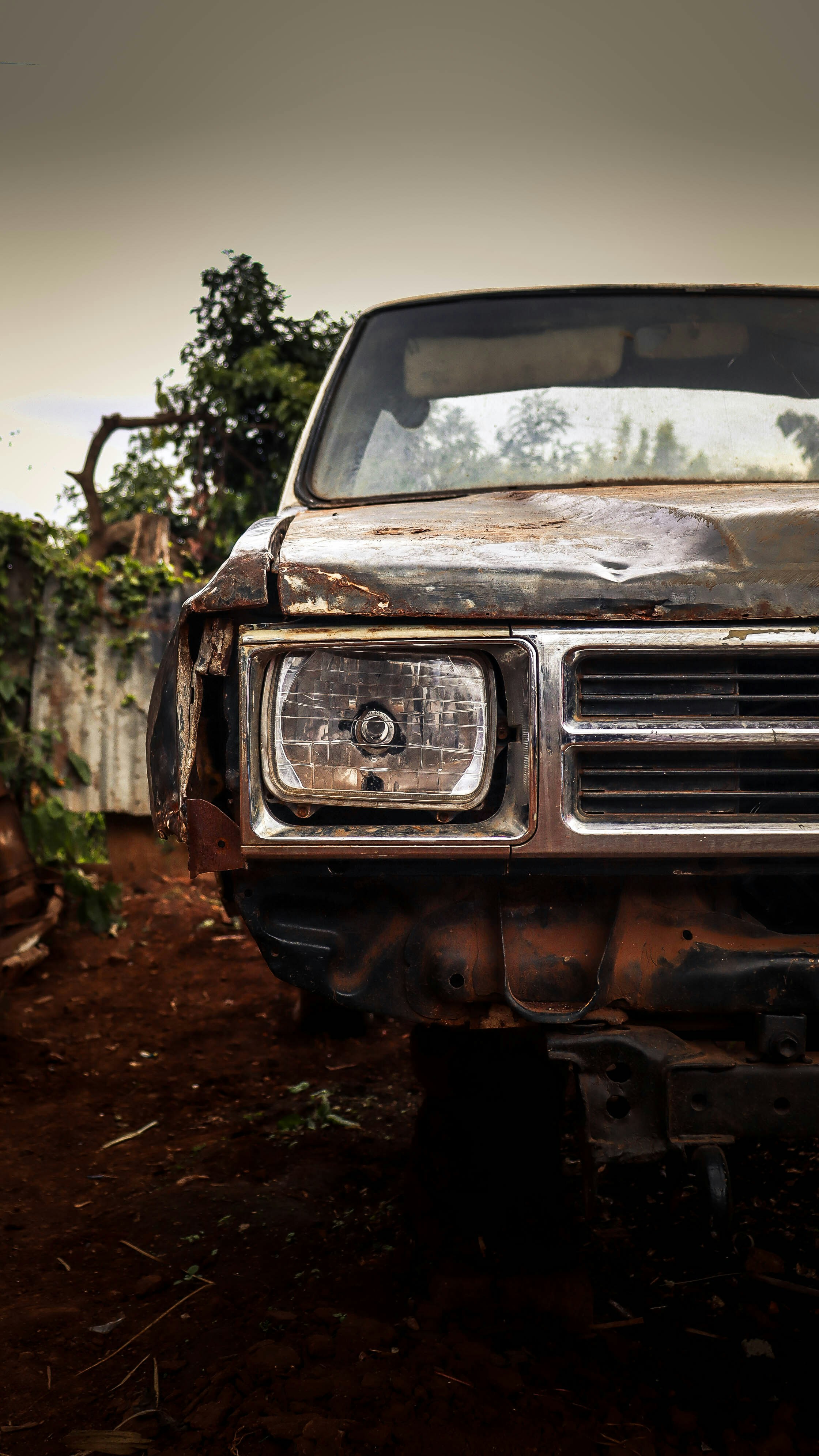 Rust-speckled Nostalgia: The Weathered Front of a Vintage Truck