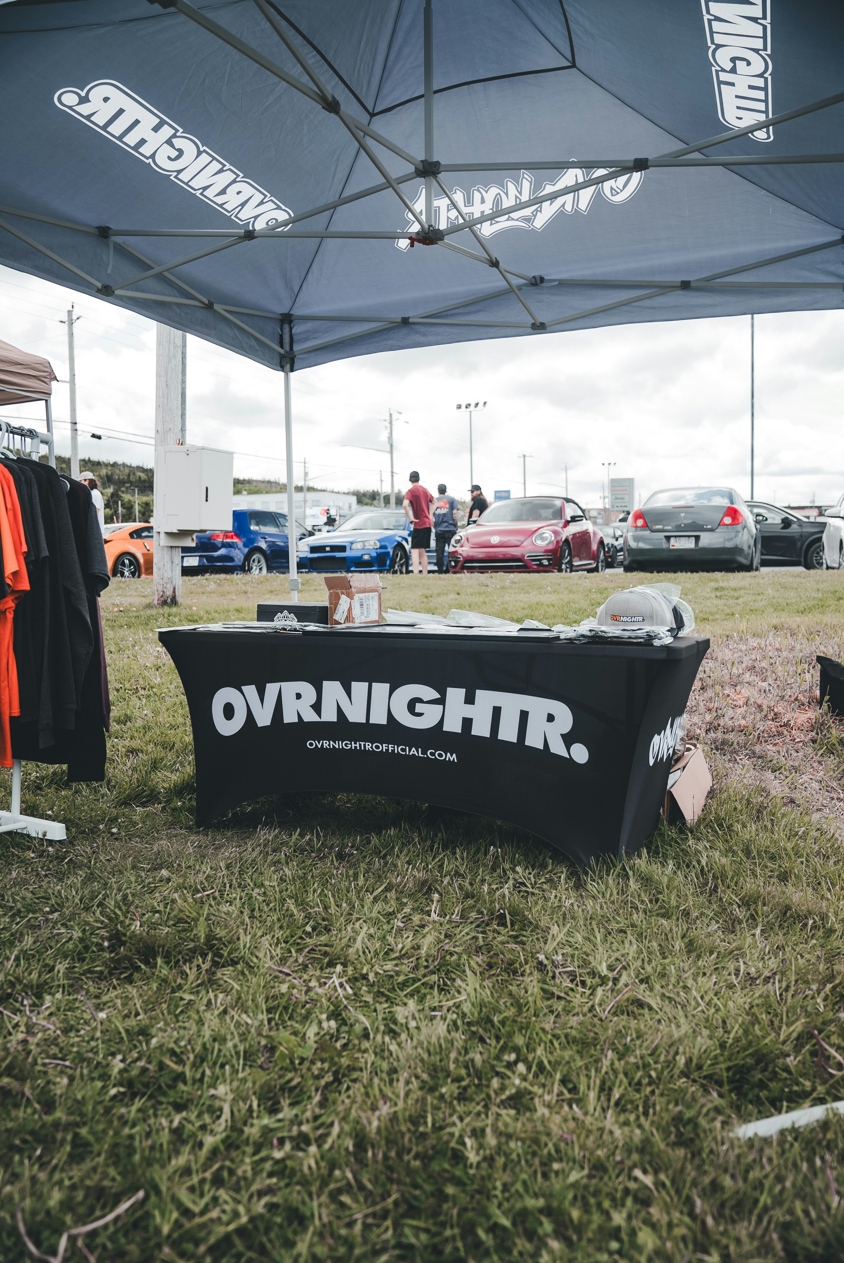 Under the Banner: A Quiet Booth at a Car Meet