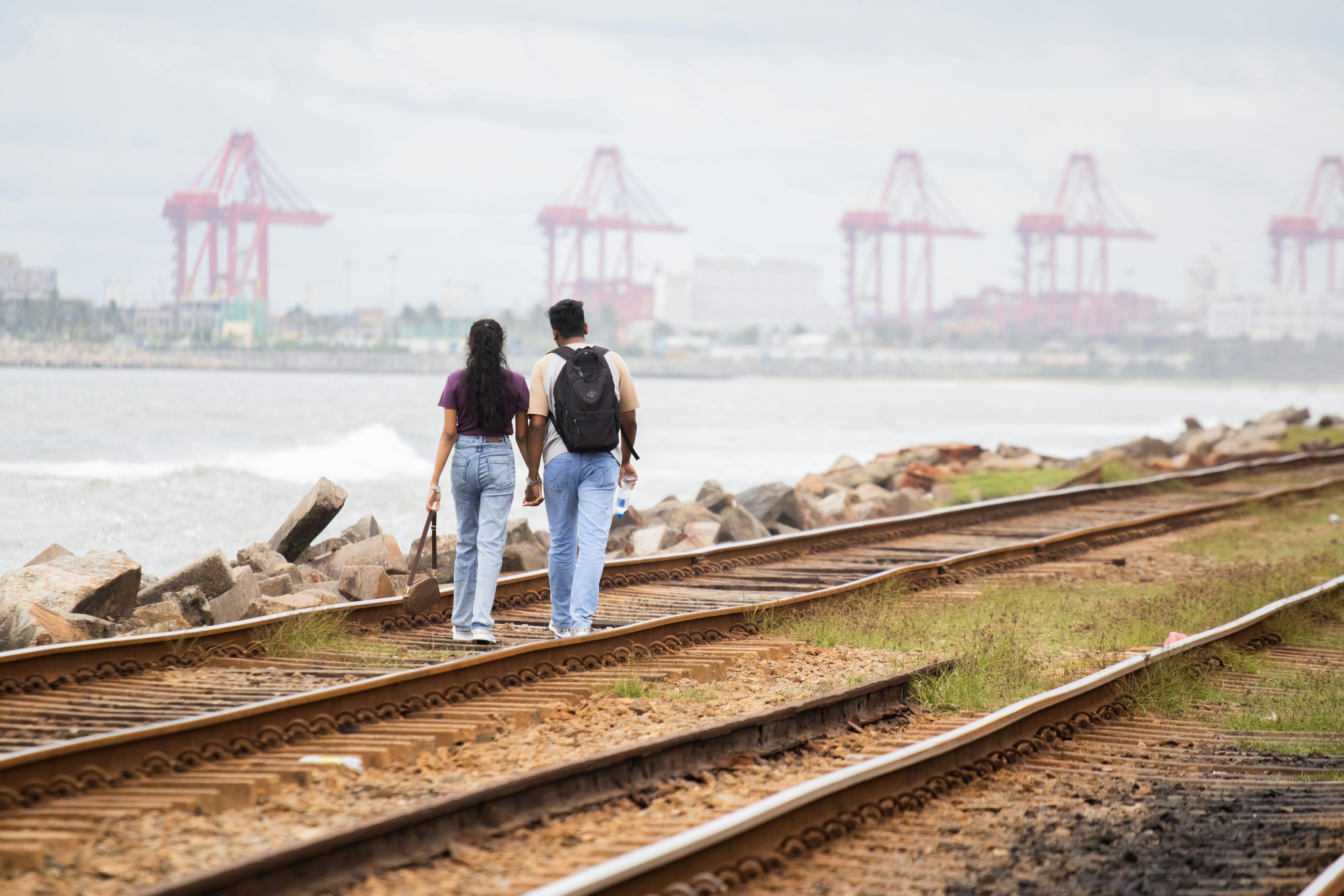 Tracks and Tides: A Quiet Walk Toward the Harbor's Red Cranes