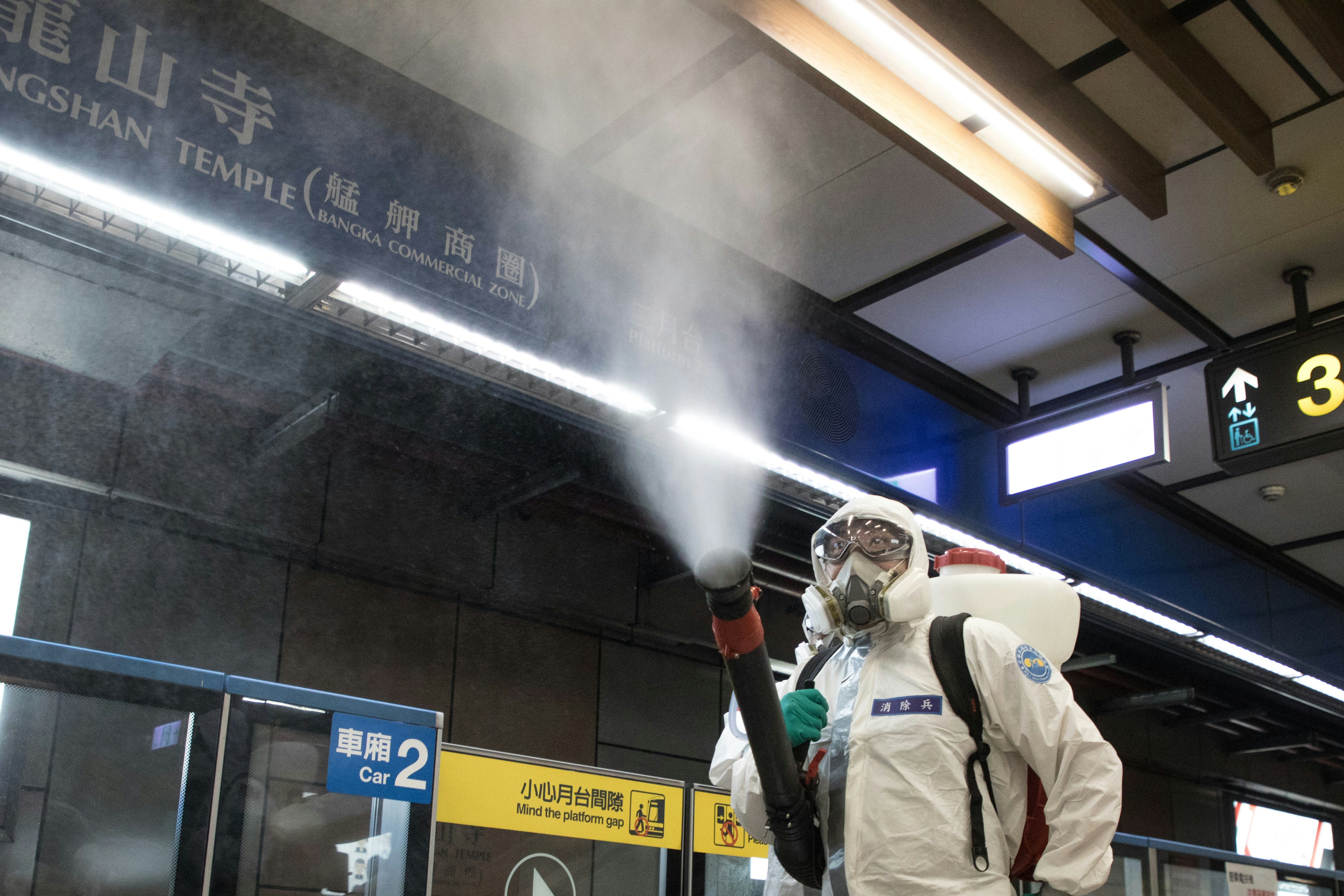 Mist at the Gate: Hazmat Operator Unfurls a Disinfectant Plume on a Subway Platform