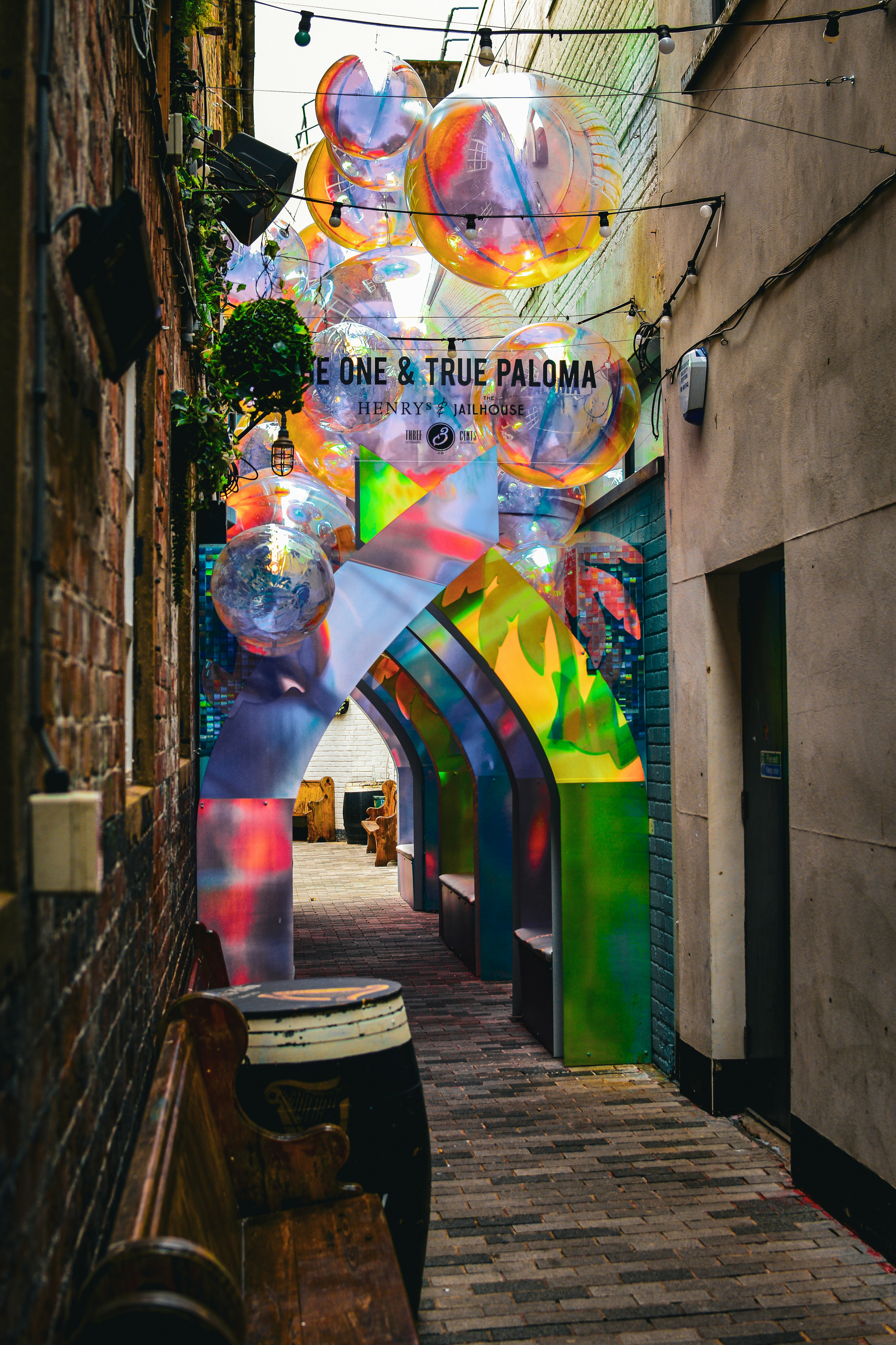 Joy's Entry Belfast | A narrow alley is decorated with lights and art.