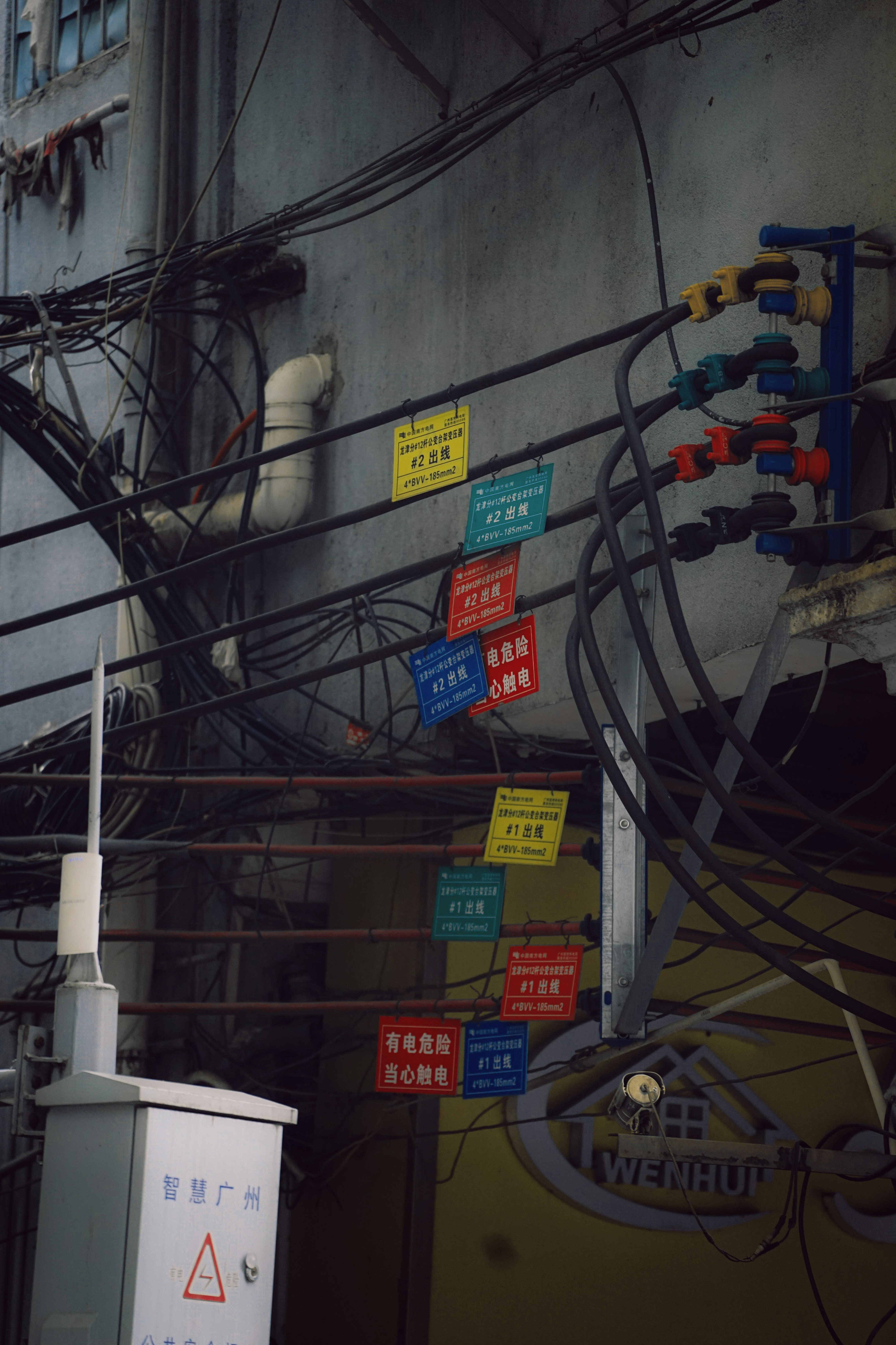 Wires and signs cover the side of a building. photo – Free Street ...