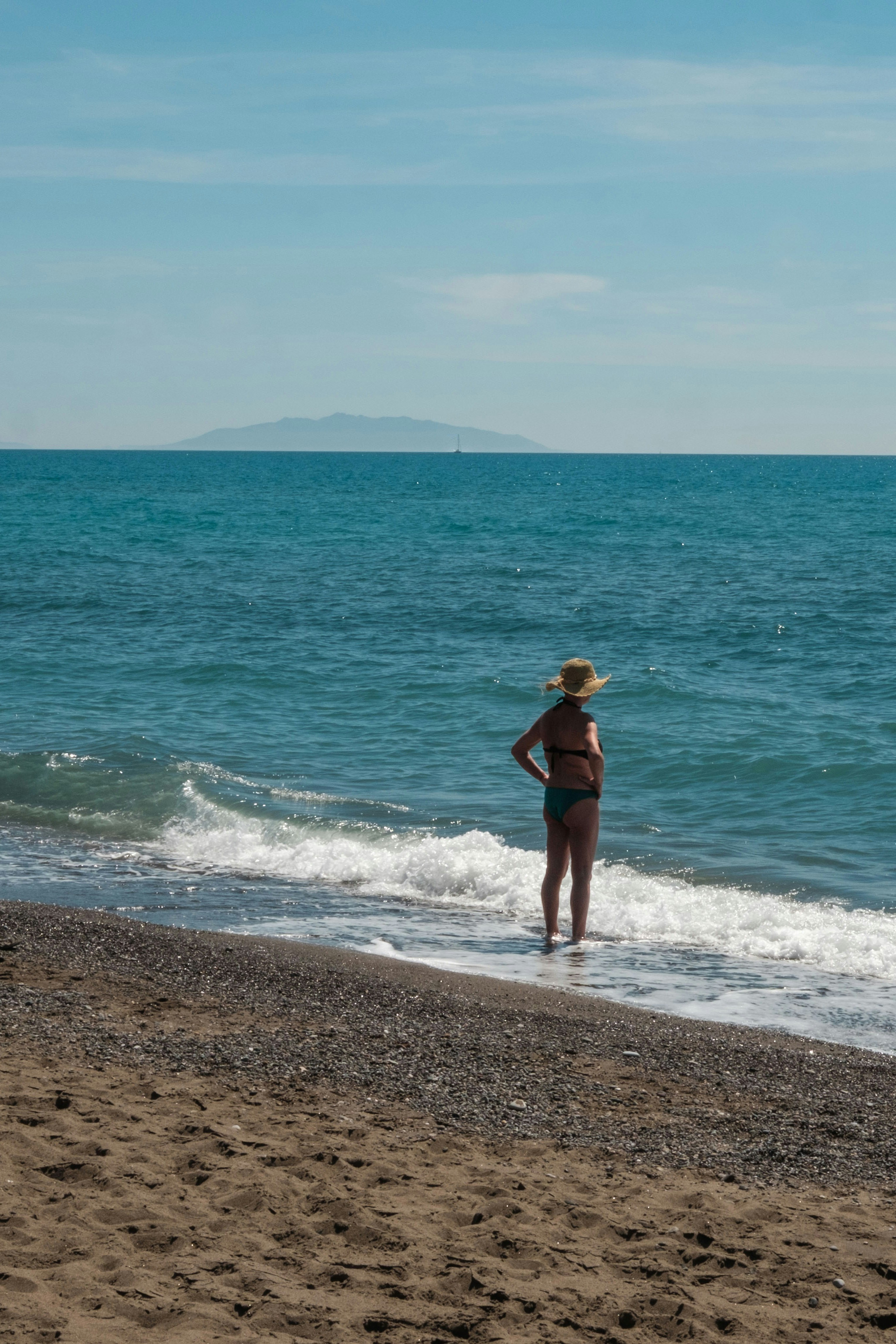 Straw Hat at the Surf's Edge: A Quiet Beach Portrait