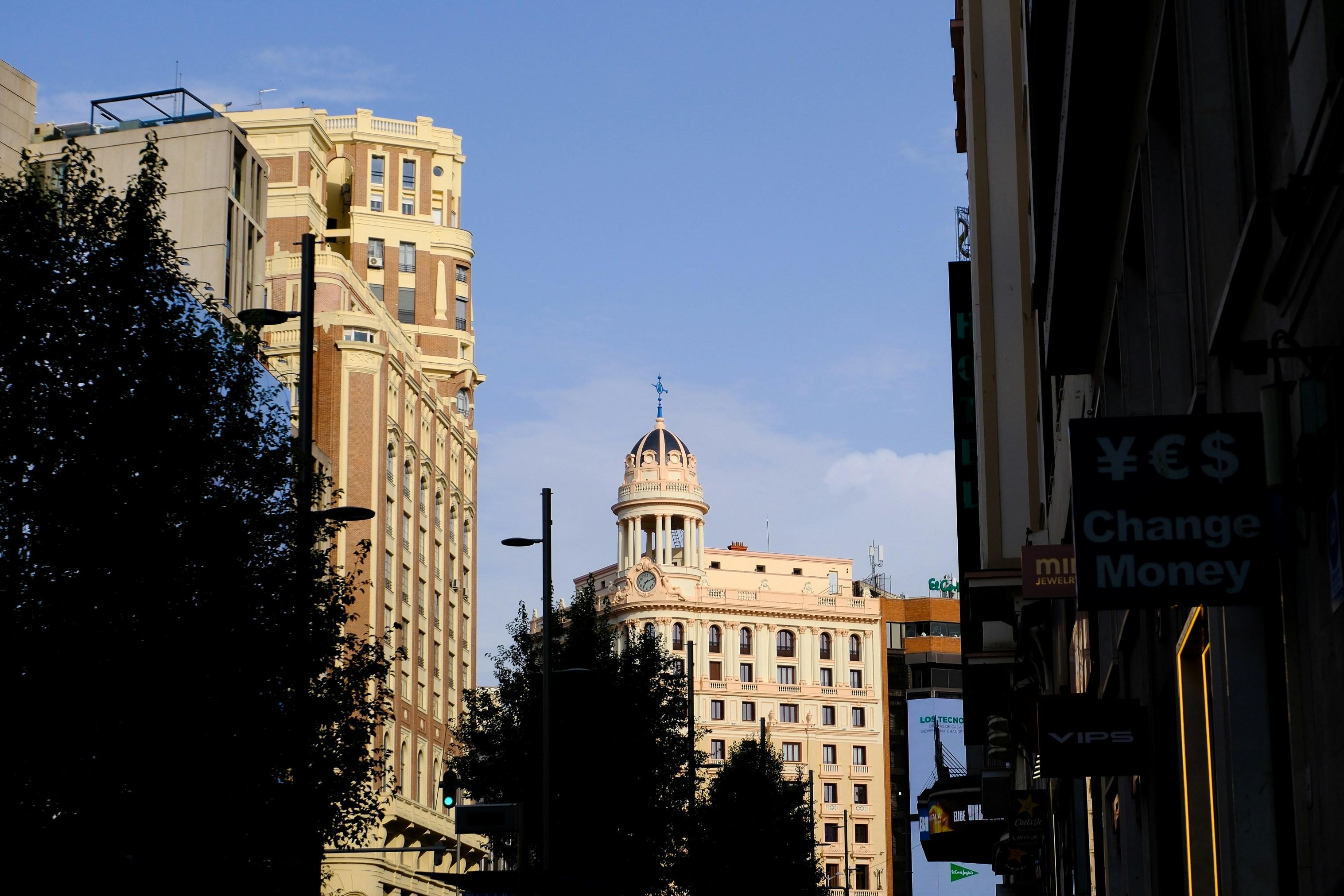 Historic buildings framed by modern architecture, showcasing a blend of styles in an urban setting.