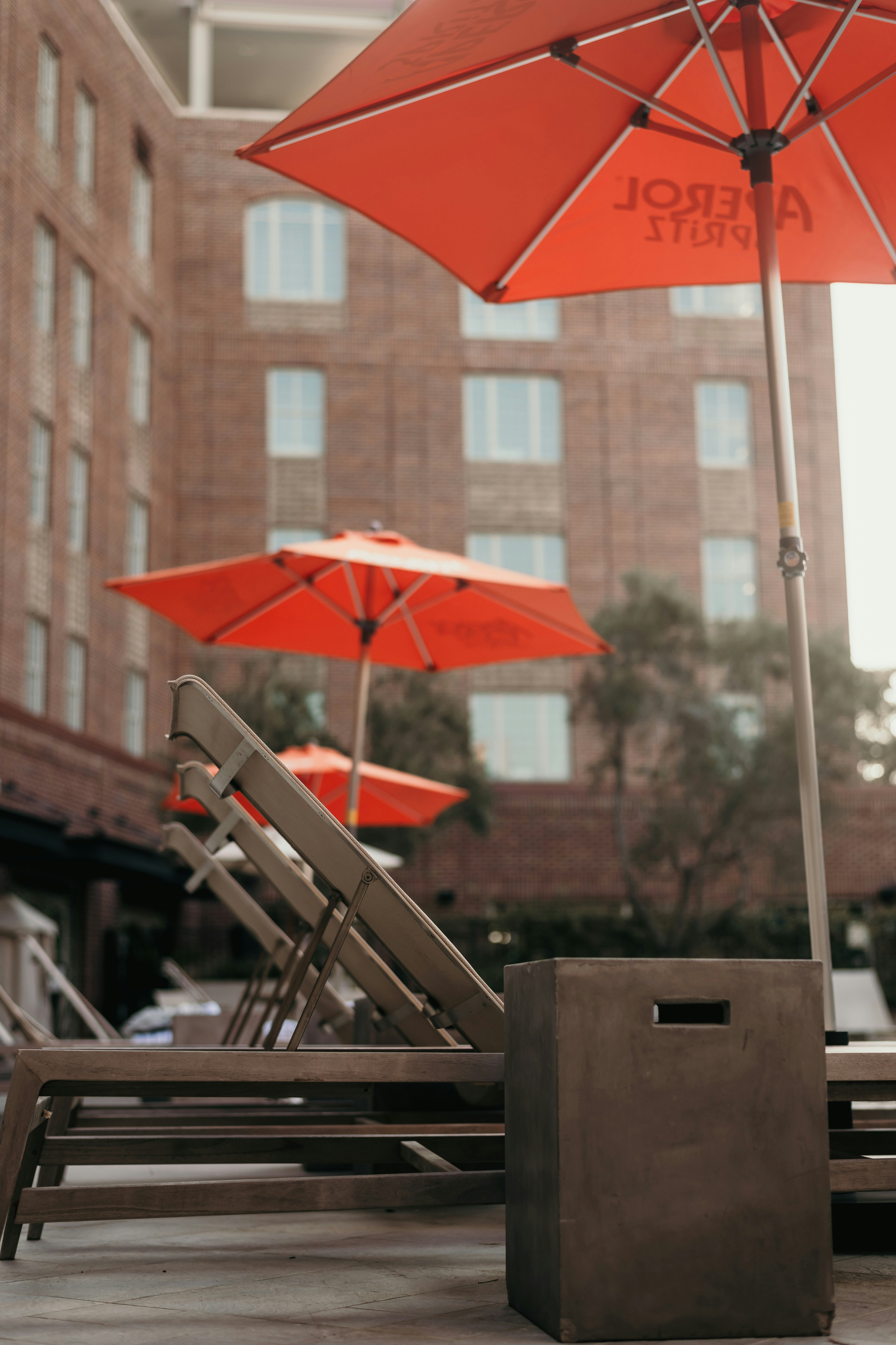 Orange Parasol Prelude over Urban Courtyard Loungers
