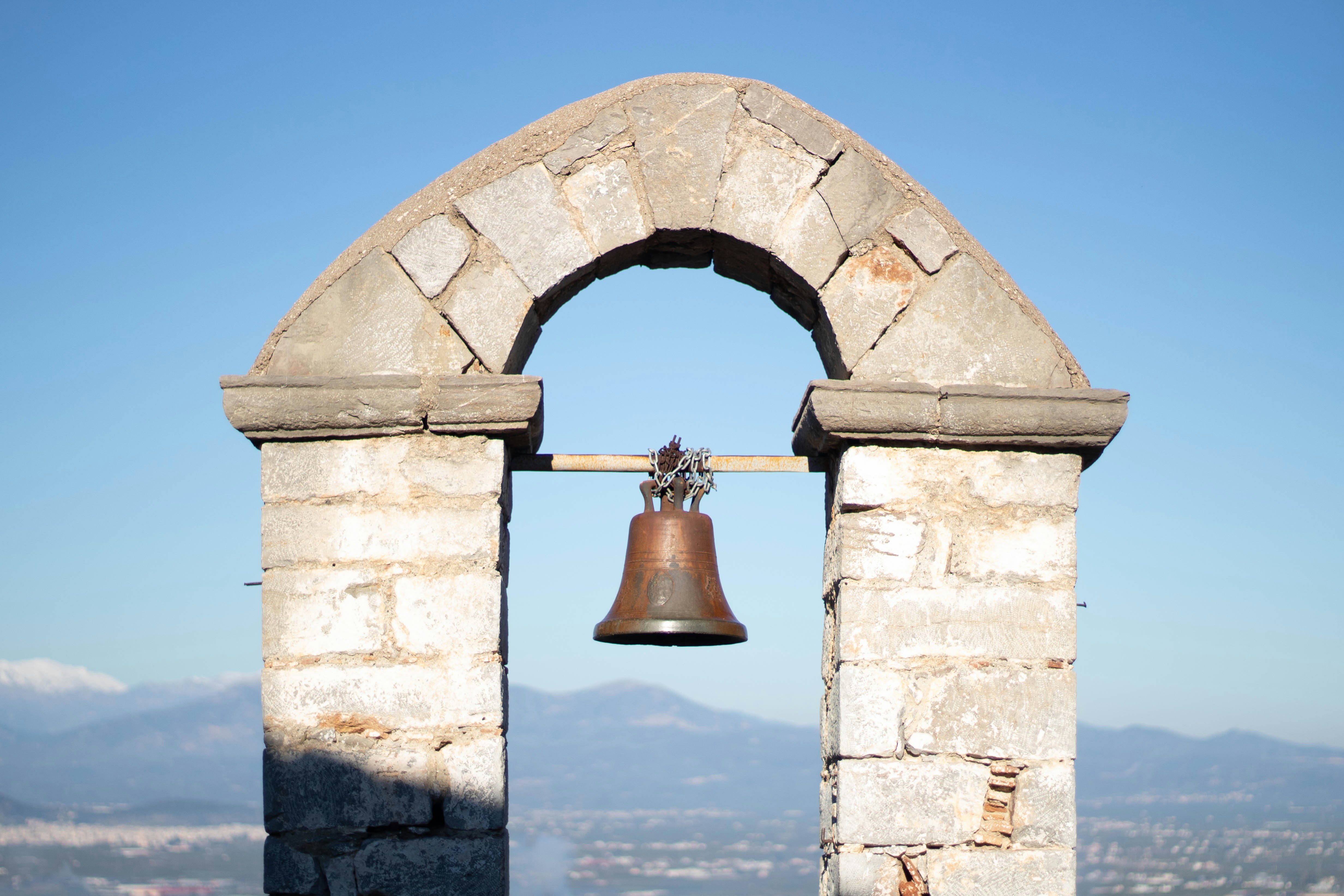 Bell in the Stone Archway Against a Mountain Vista