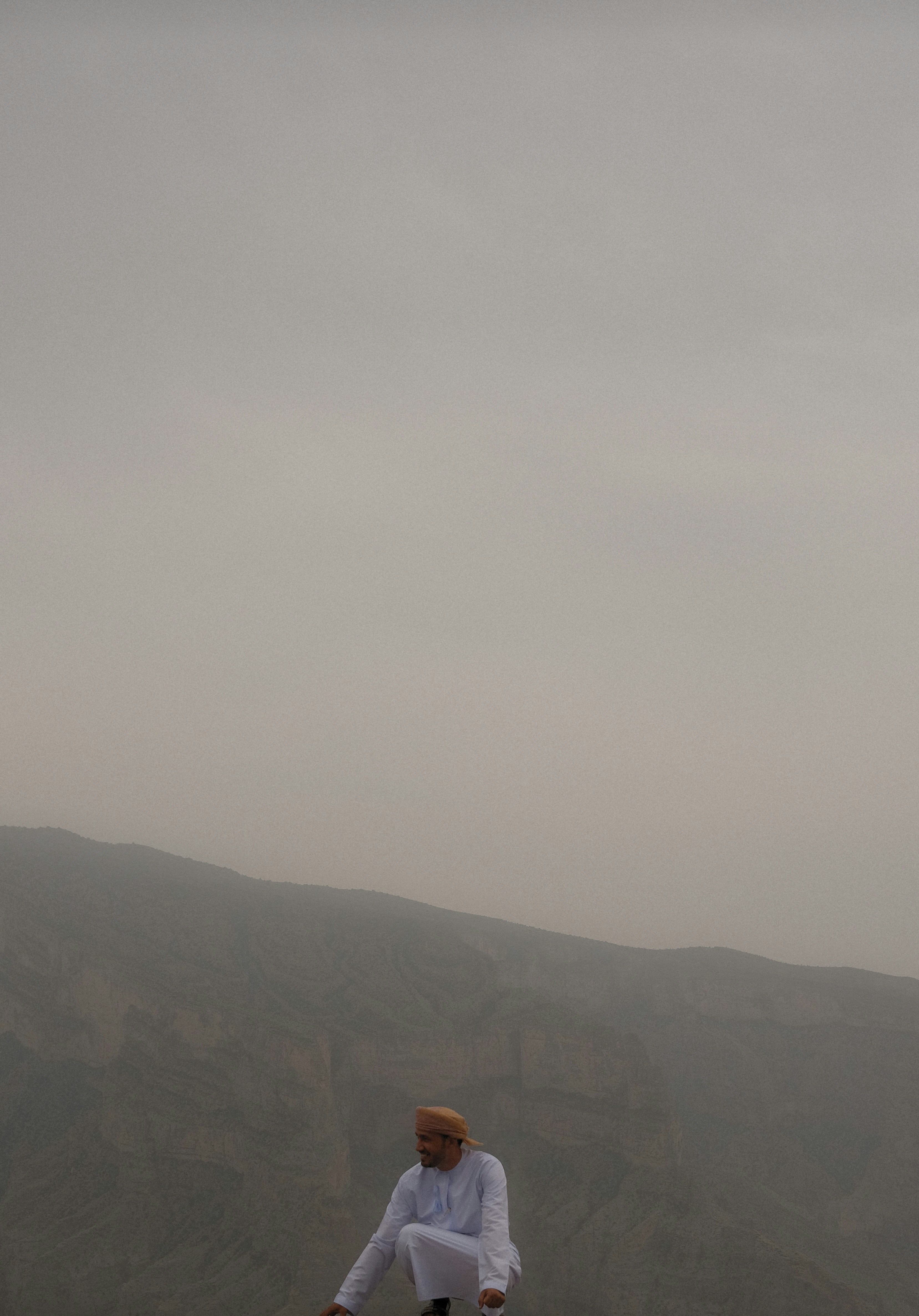 Solitary Sitter on a Mist-Wracked Canyon Ridge