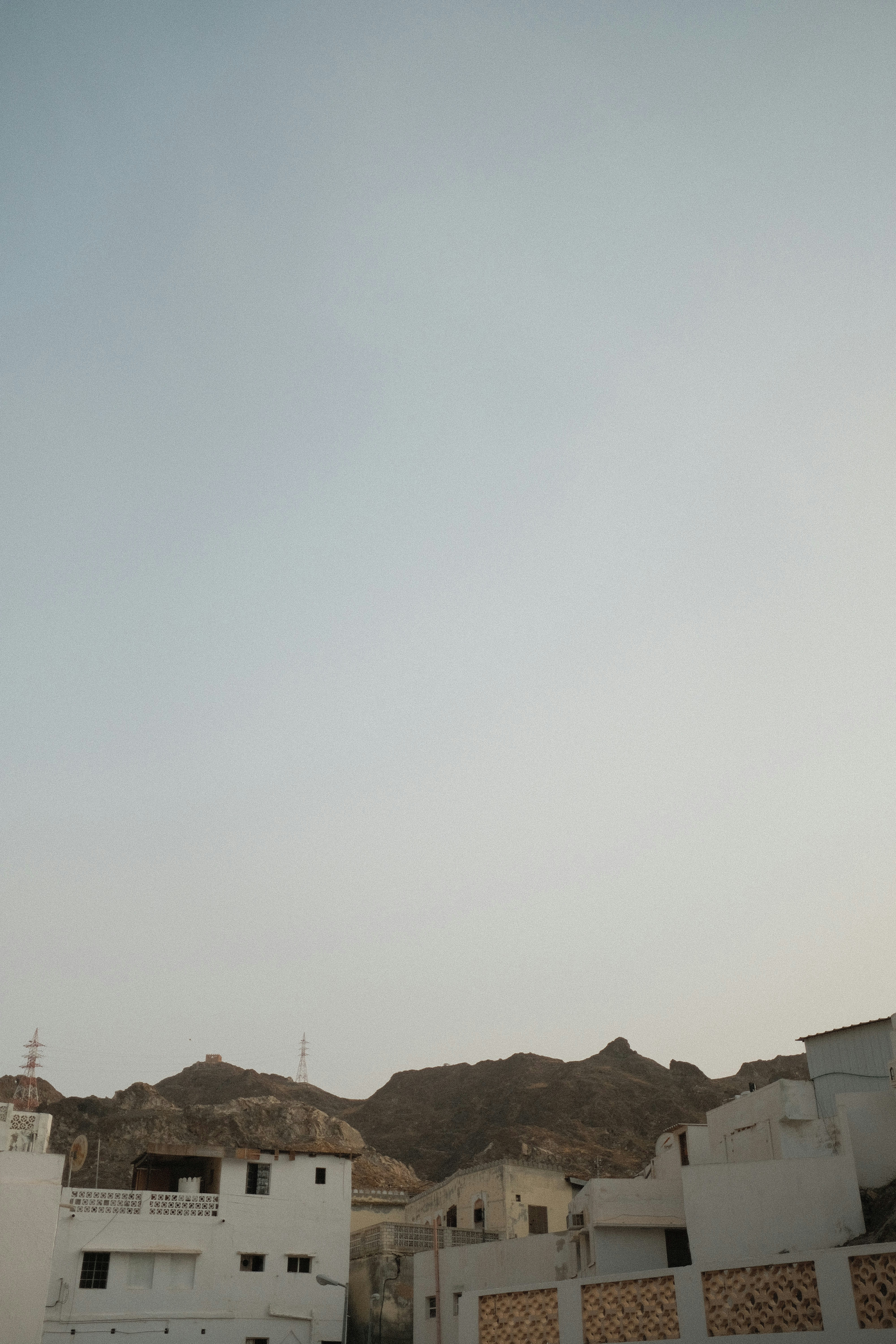 Buildings sit below a rocky mountain.