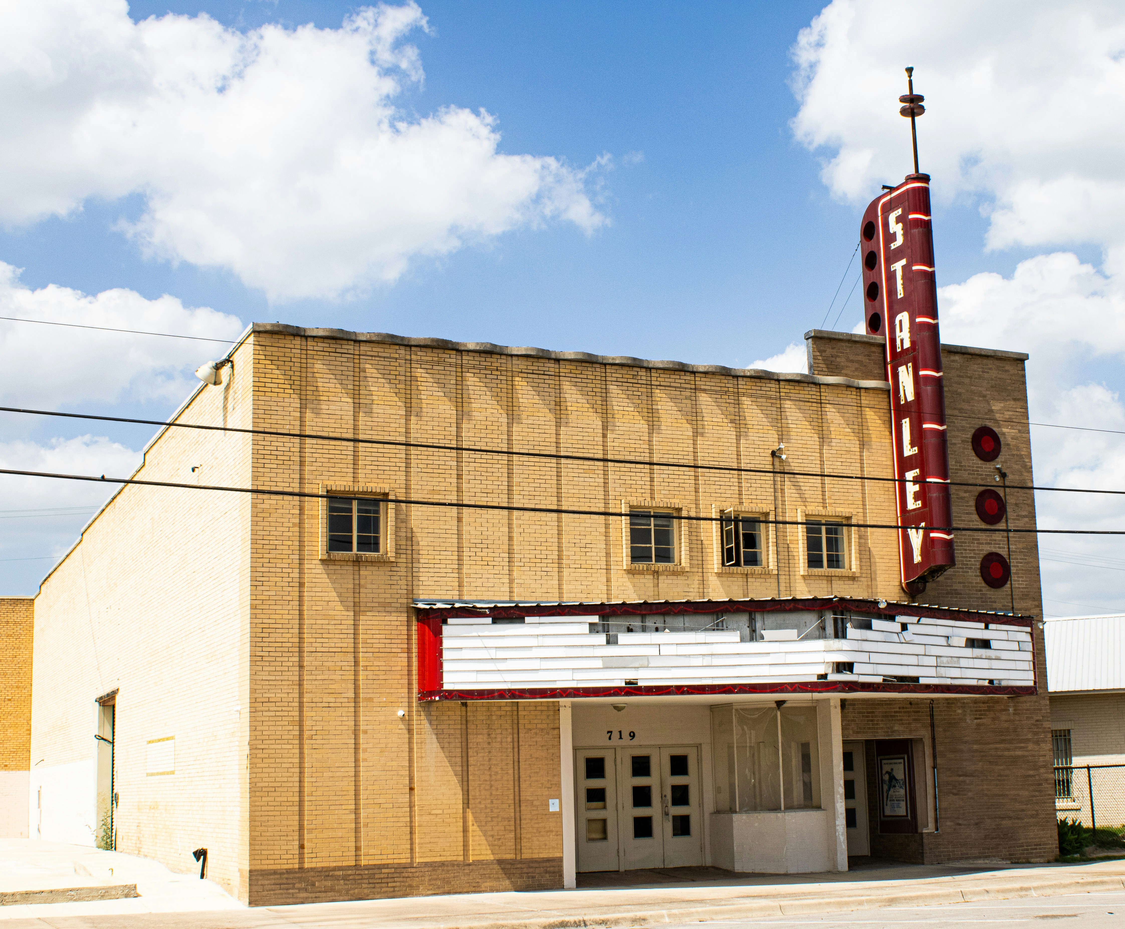 Historic Stanley Theatre exterior showcasing its vintage architecture and marquee under a bright blue sky.