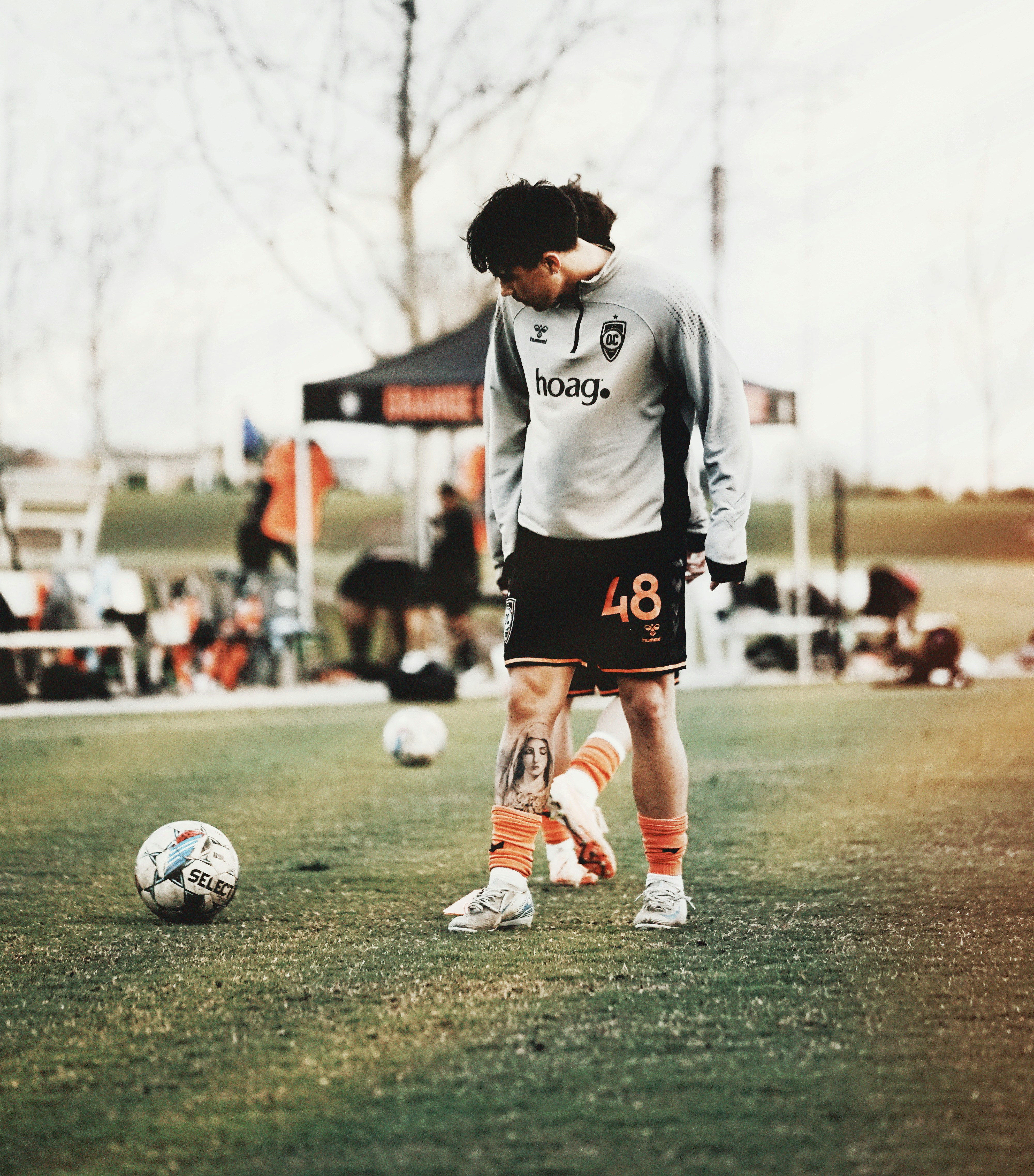 Gray Jersey, Orange Socks: A Moment of Intent on the Grass