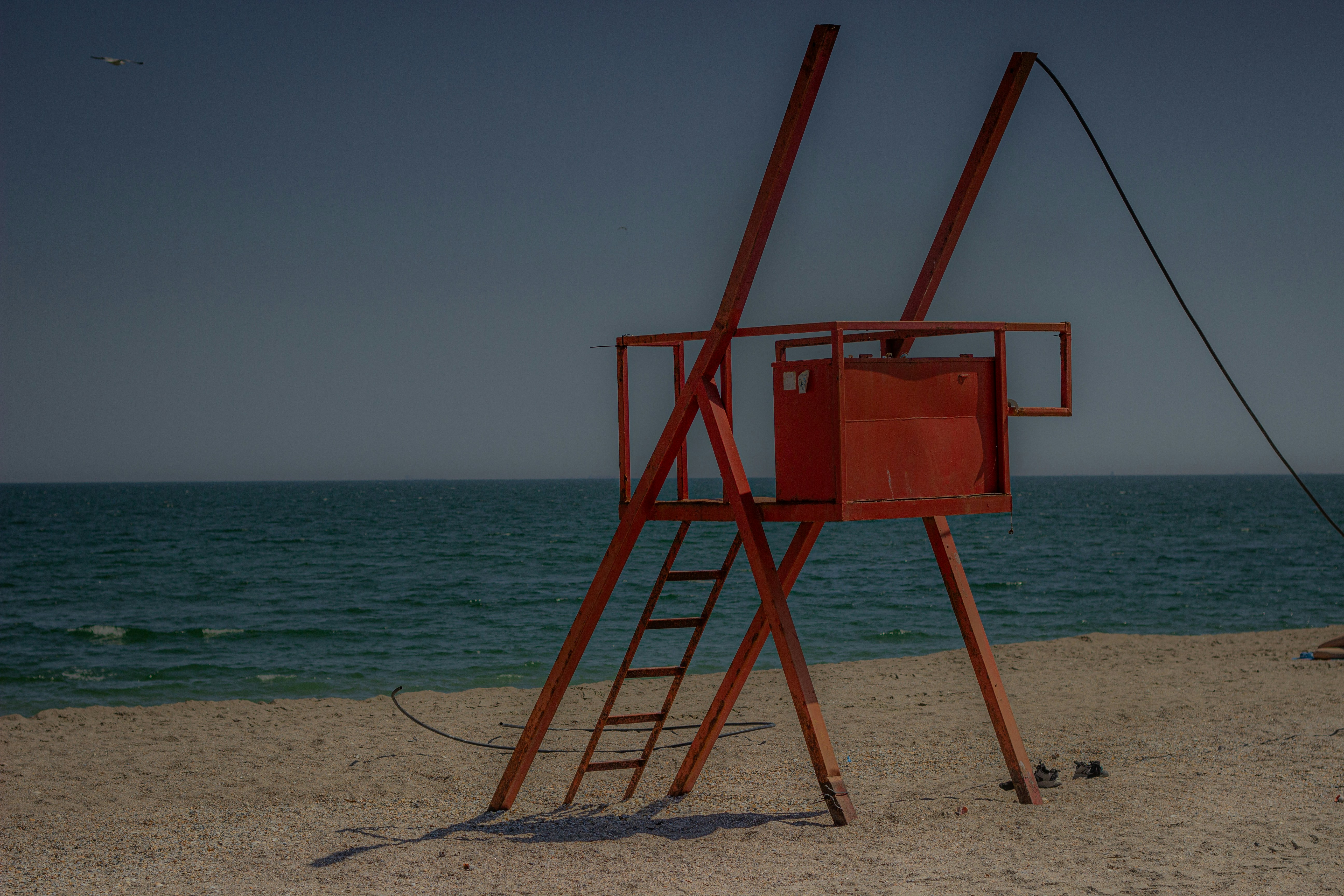 Red Sentinel on the Shore: Lifeguard Tower Framing the Quiet Sea