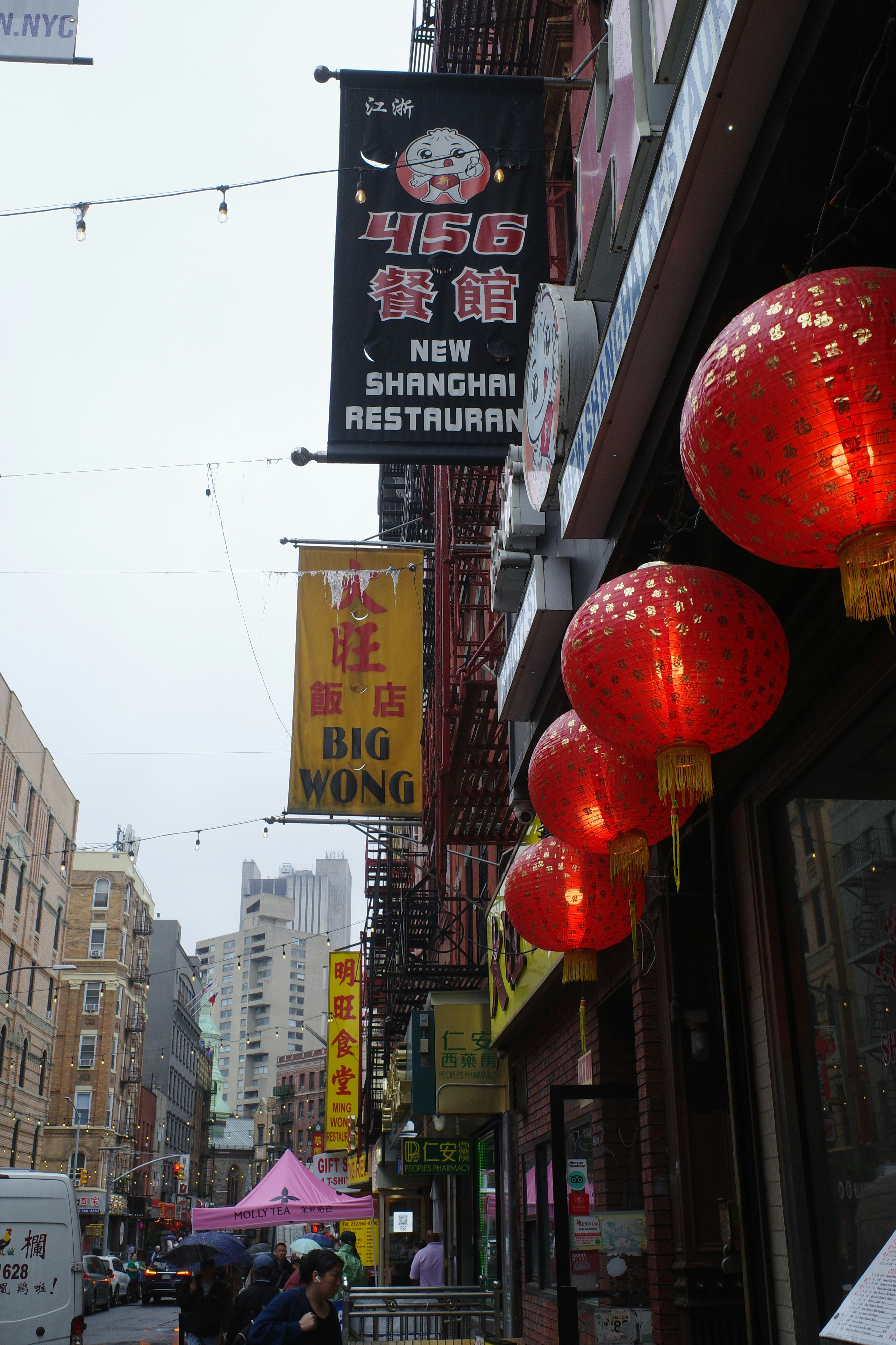 Chinatown street scene with lanterns and restaurant signs.
