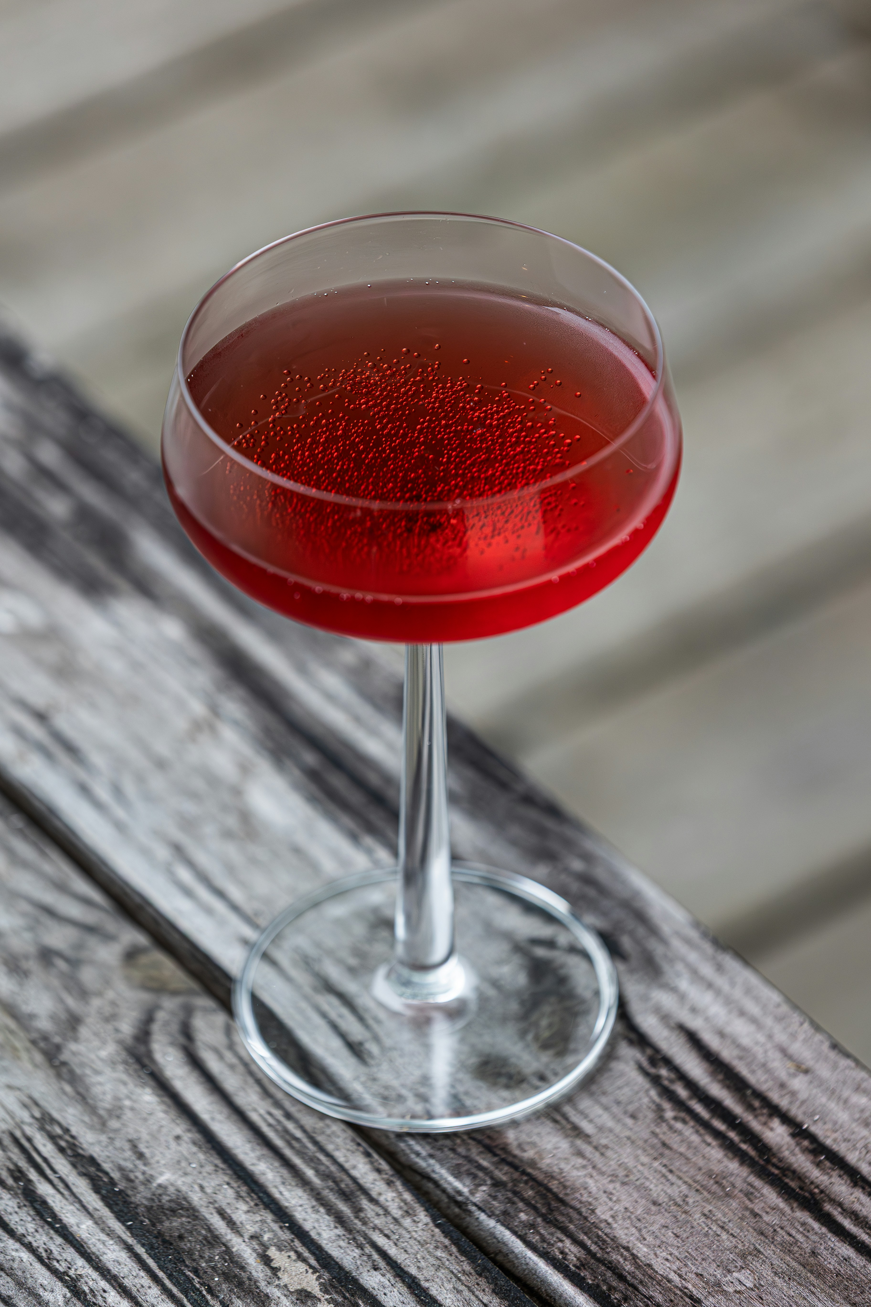 A red cocktail in a elegant glass.