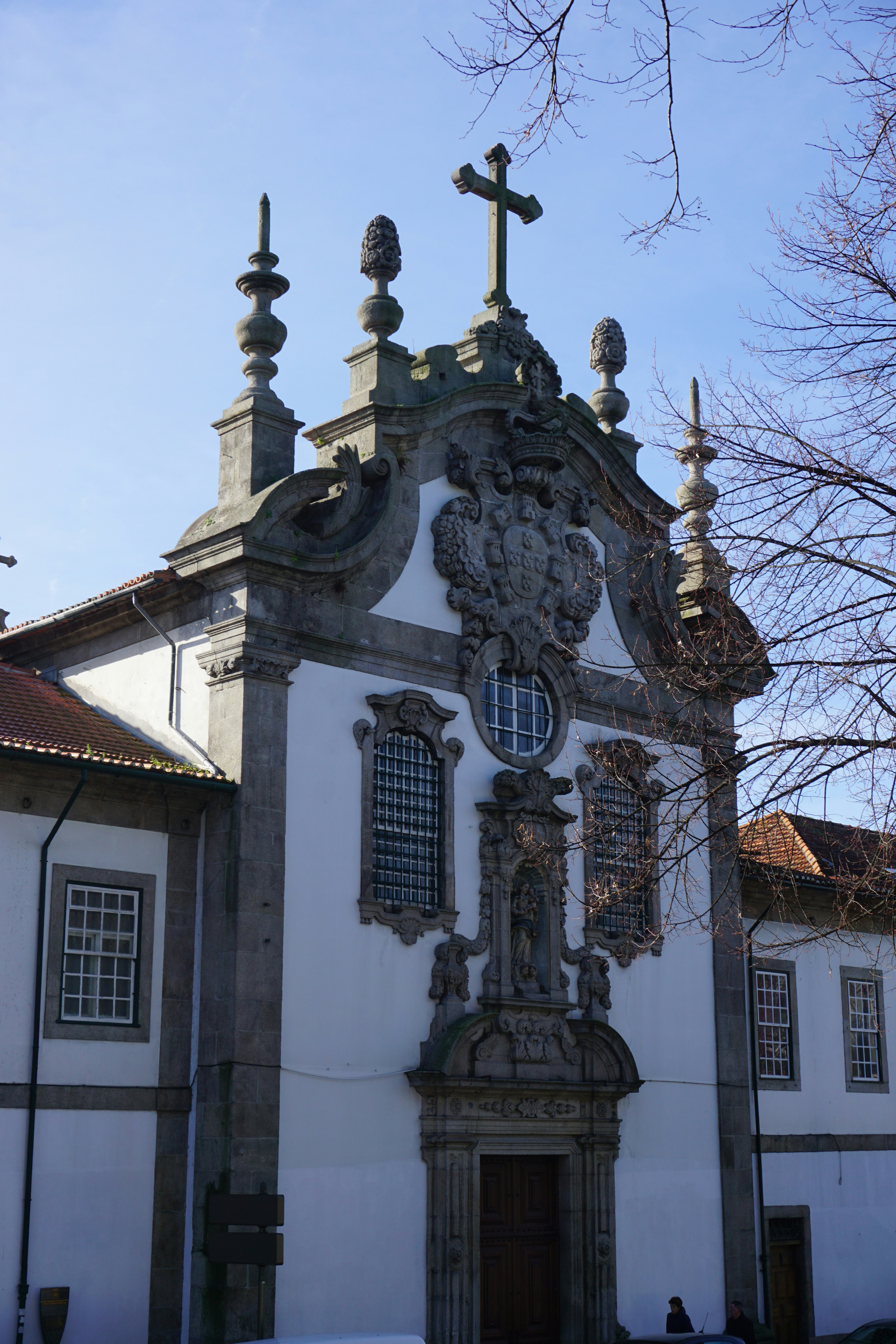 Elaborate Baroque church facade featuring intricate sculptures and a prominent cross atop the structure.