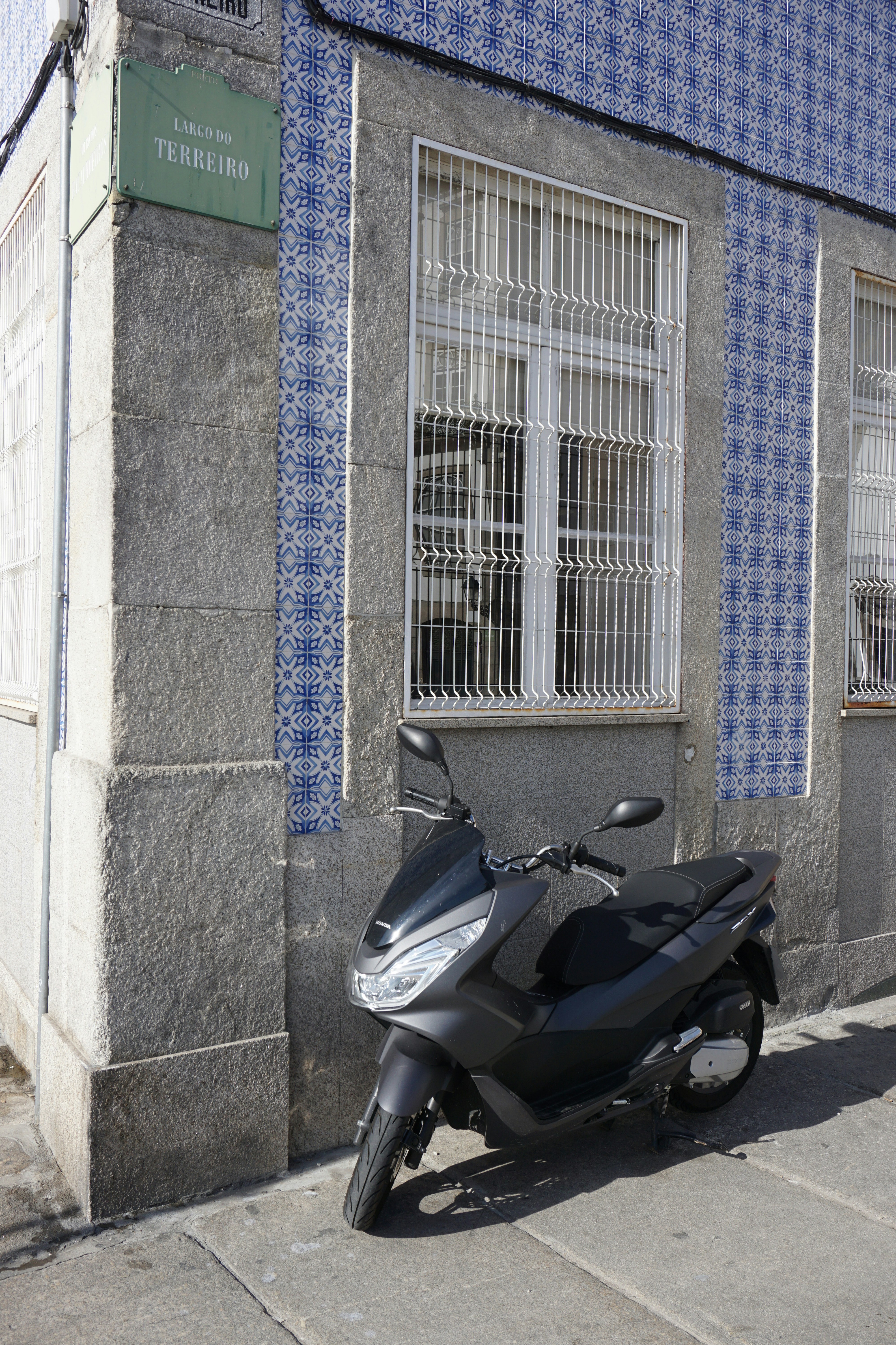 Blue-tiled Street Corner with Modern Scooter