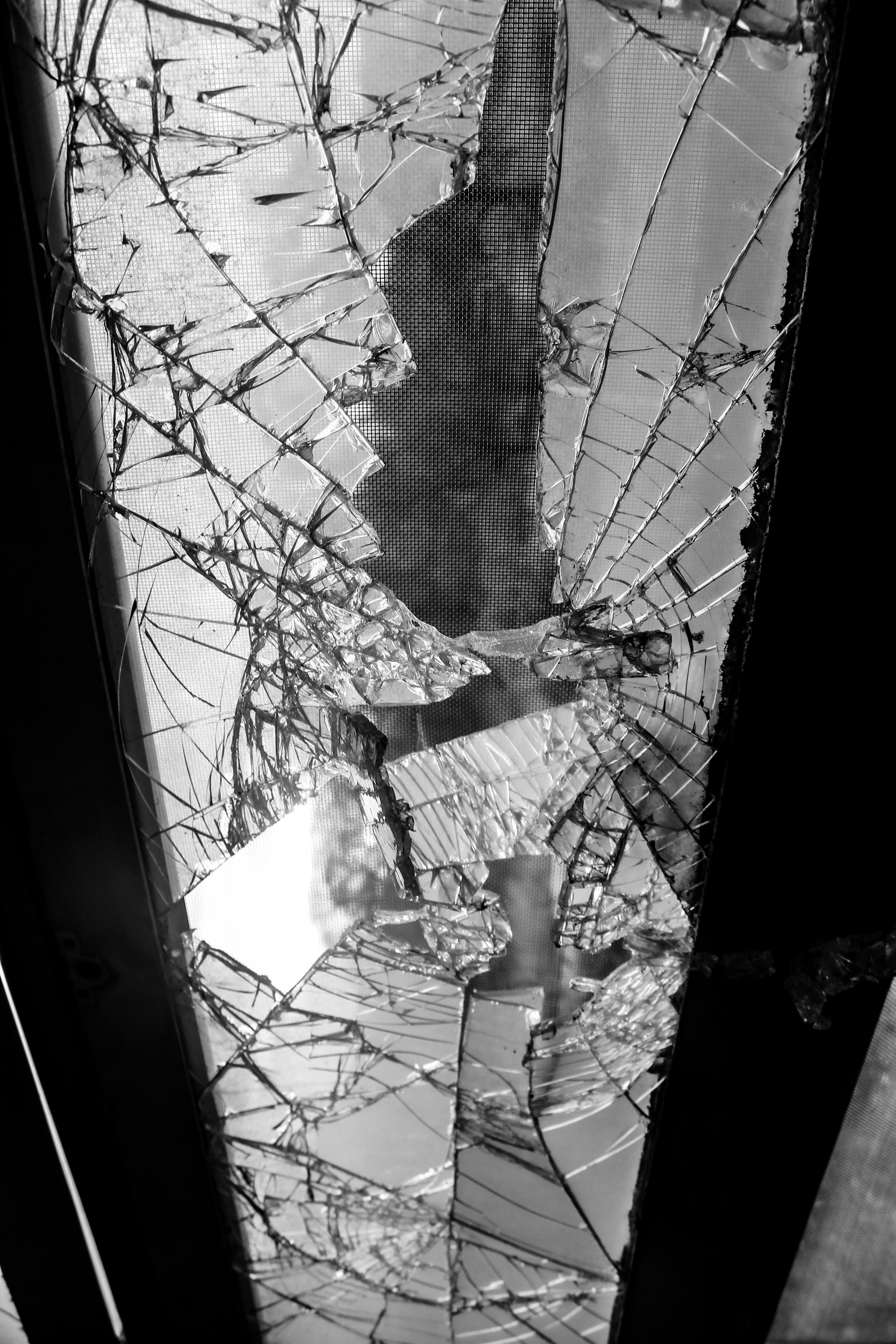 Broken glass in an abandoned building | Shattered glass reveals the dark outside.