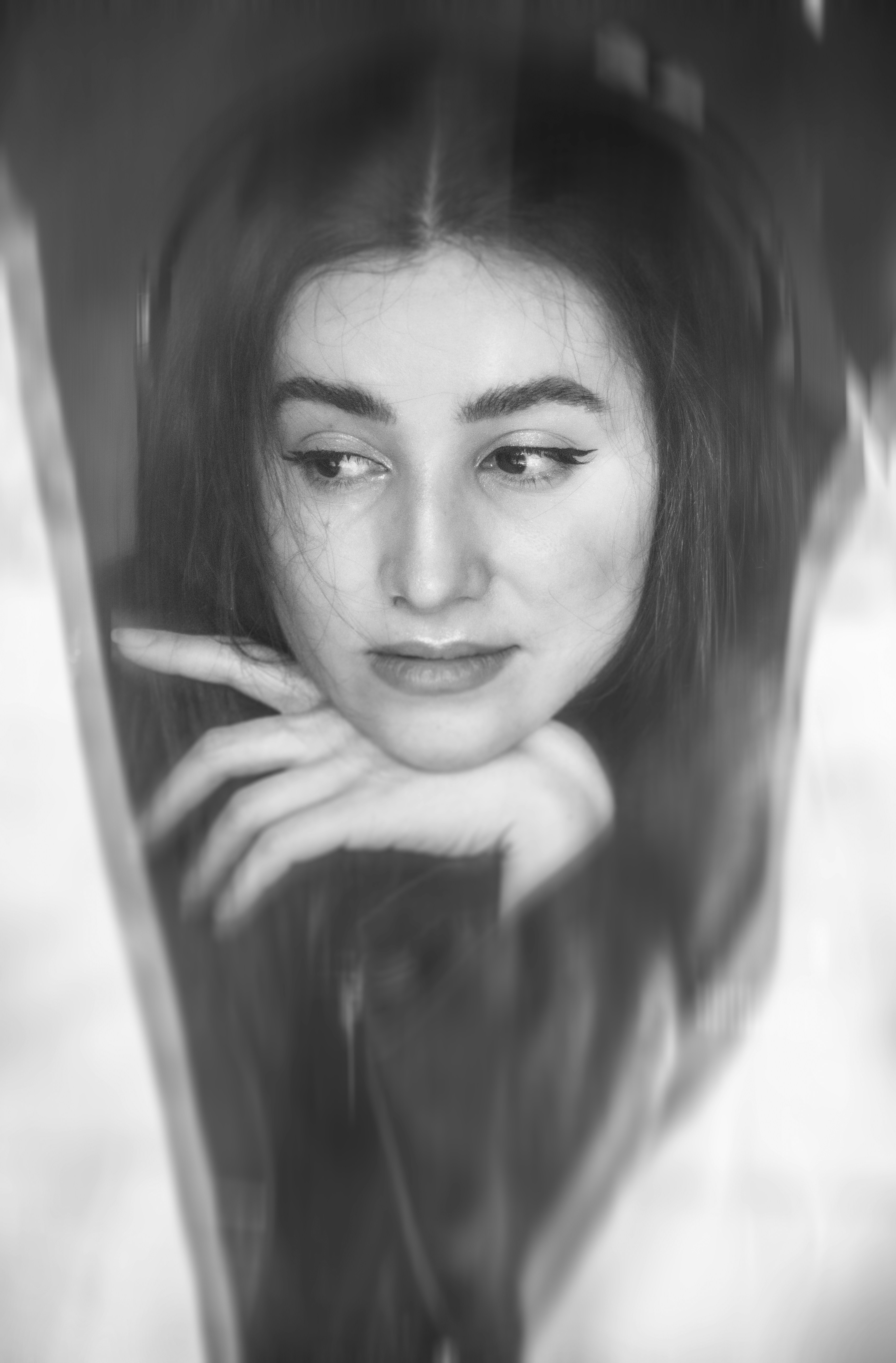 A beautiful girl with a pensive look. | A pensive woman poses in black and white.