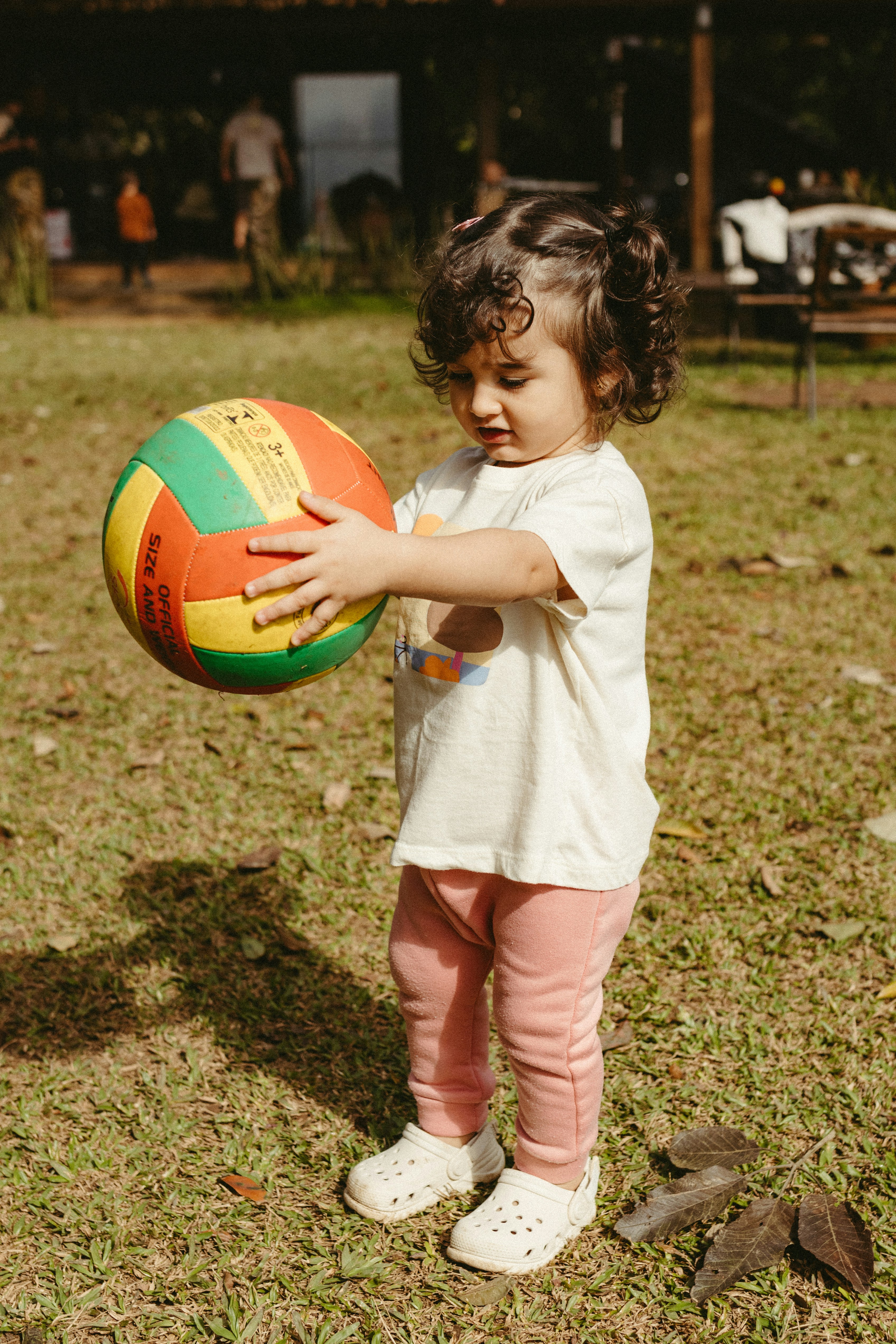 A child holds a colorful ball.