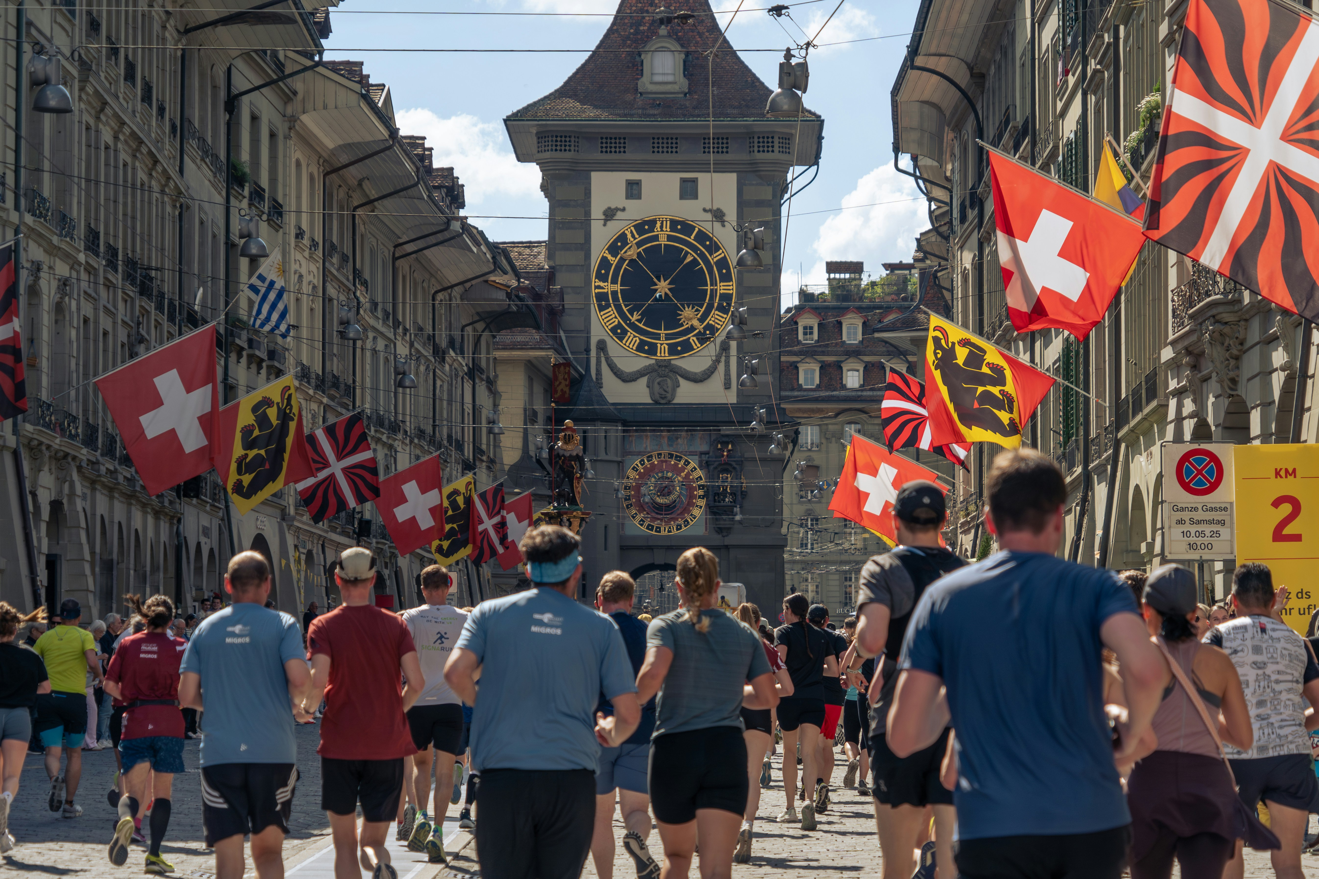 Chasing Time on Bern's Flag-Lined Boulevard under the Clock Tower