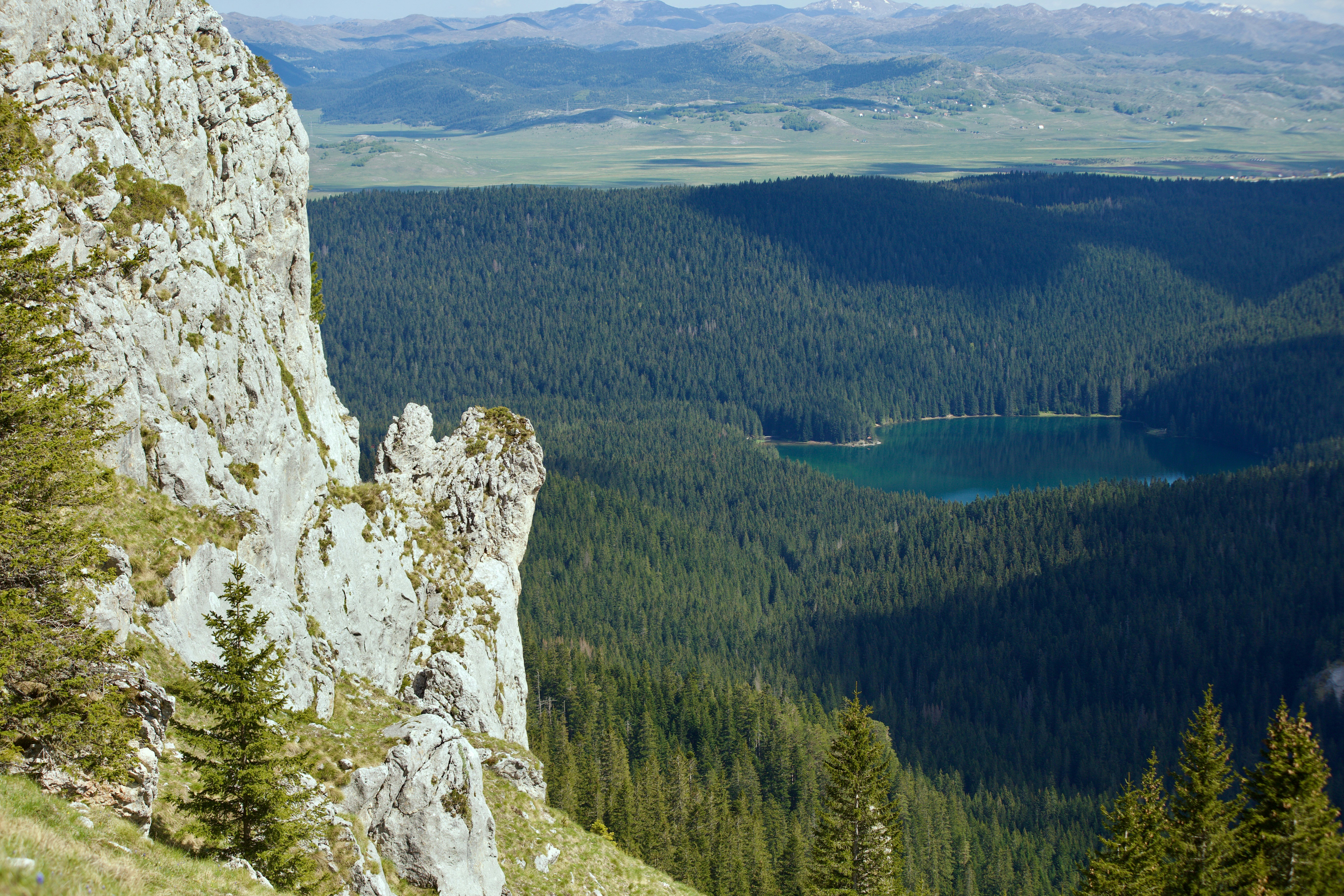 Granite Edge Over a Pine-Valley and Distant Lake
