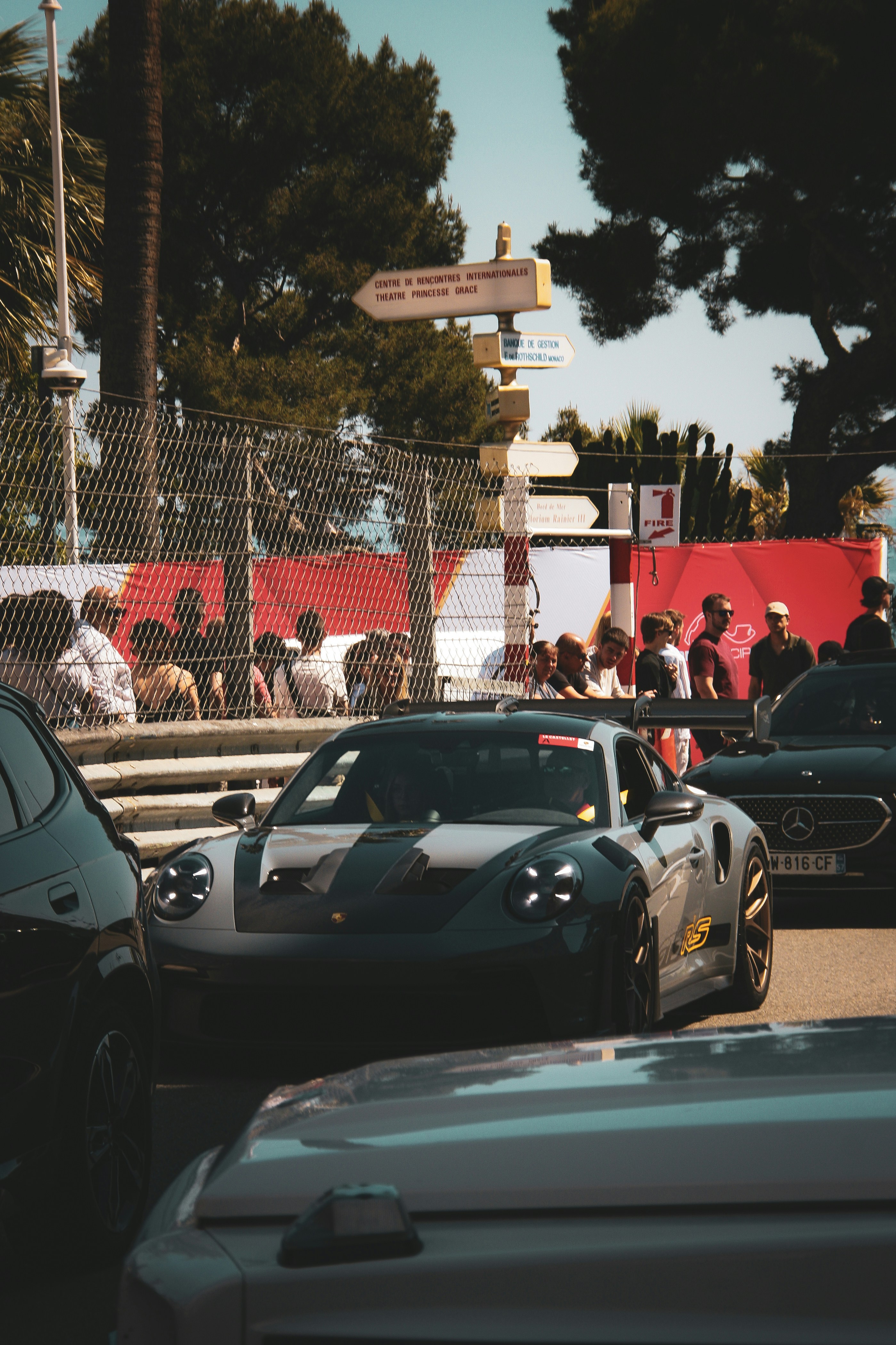 Green Porsche 911 Commands the Frame Amid a Crowded Pit-Edge Scene