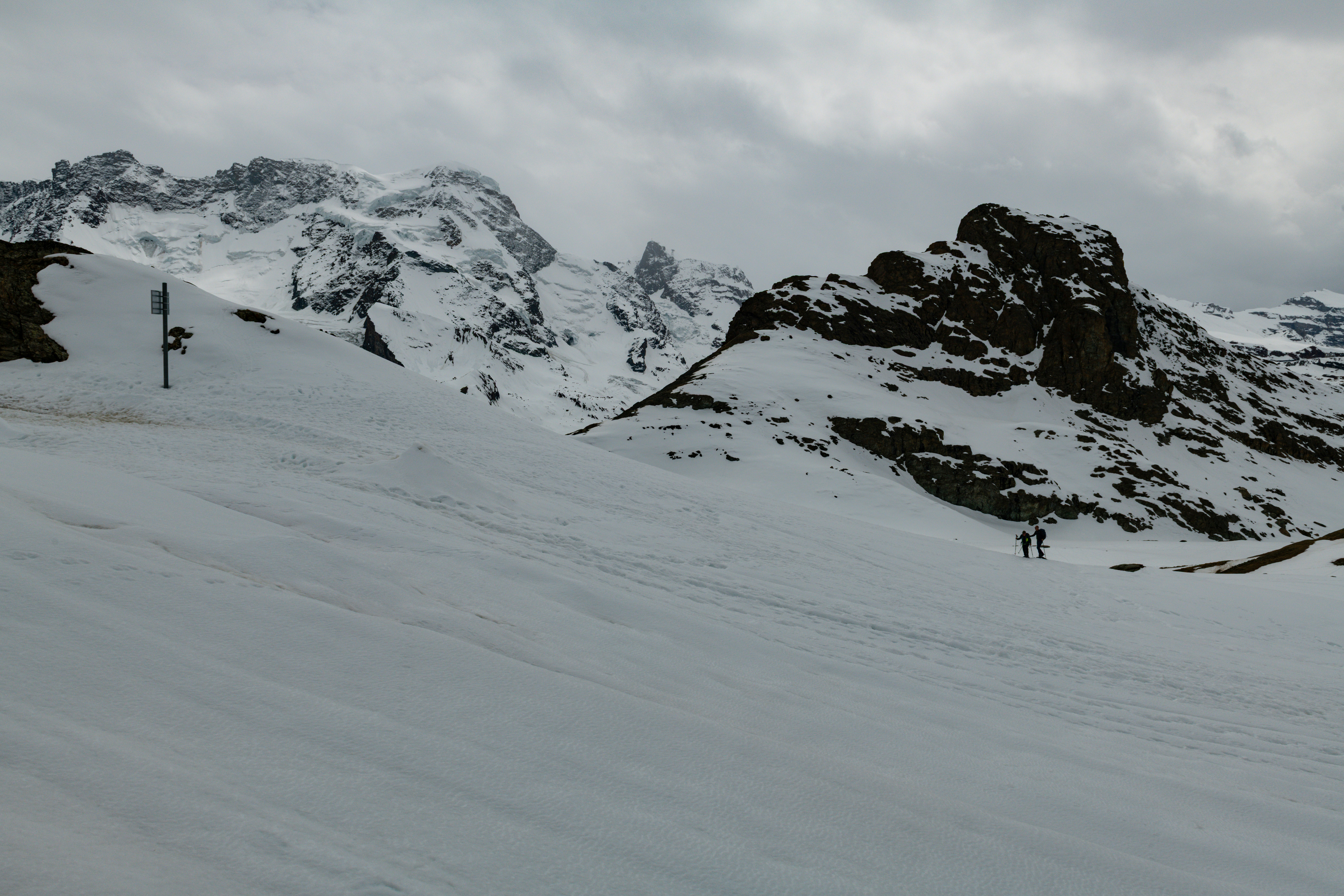 Snowy mountain range with a cloudy sky.